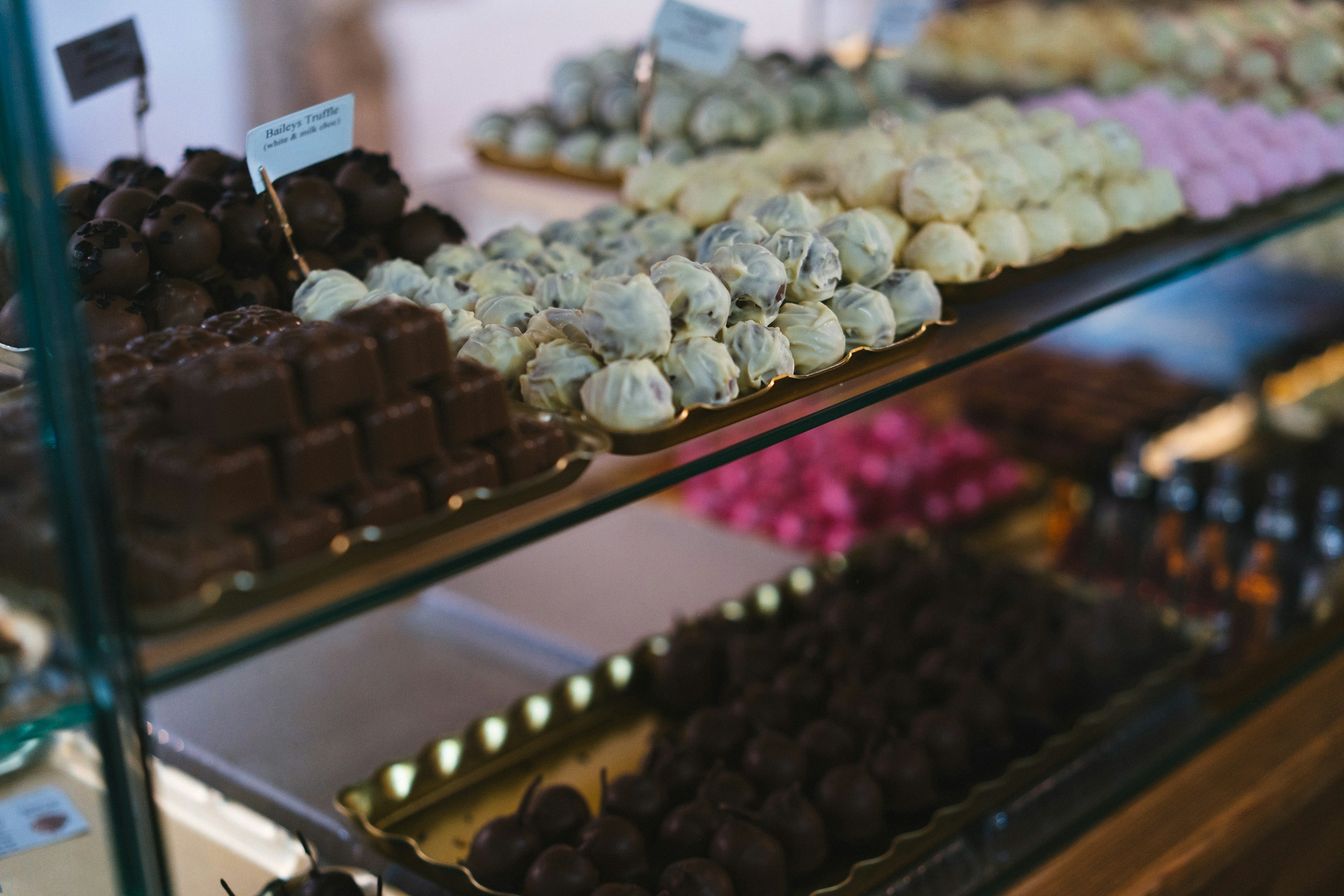 A display case filled with lots of different types of chocolates photo ...