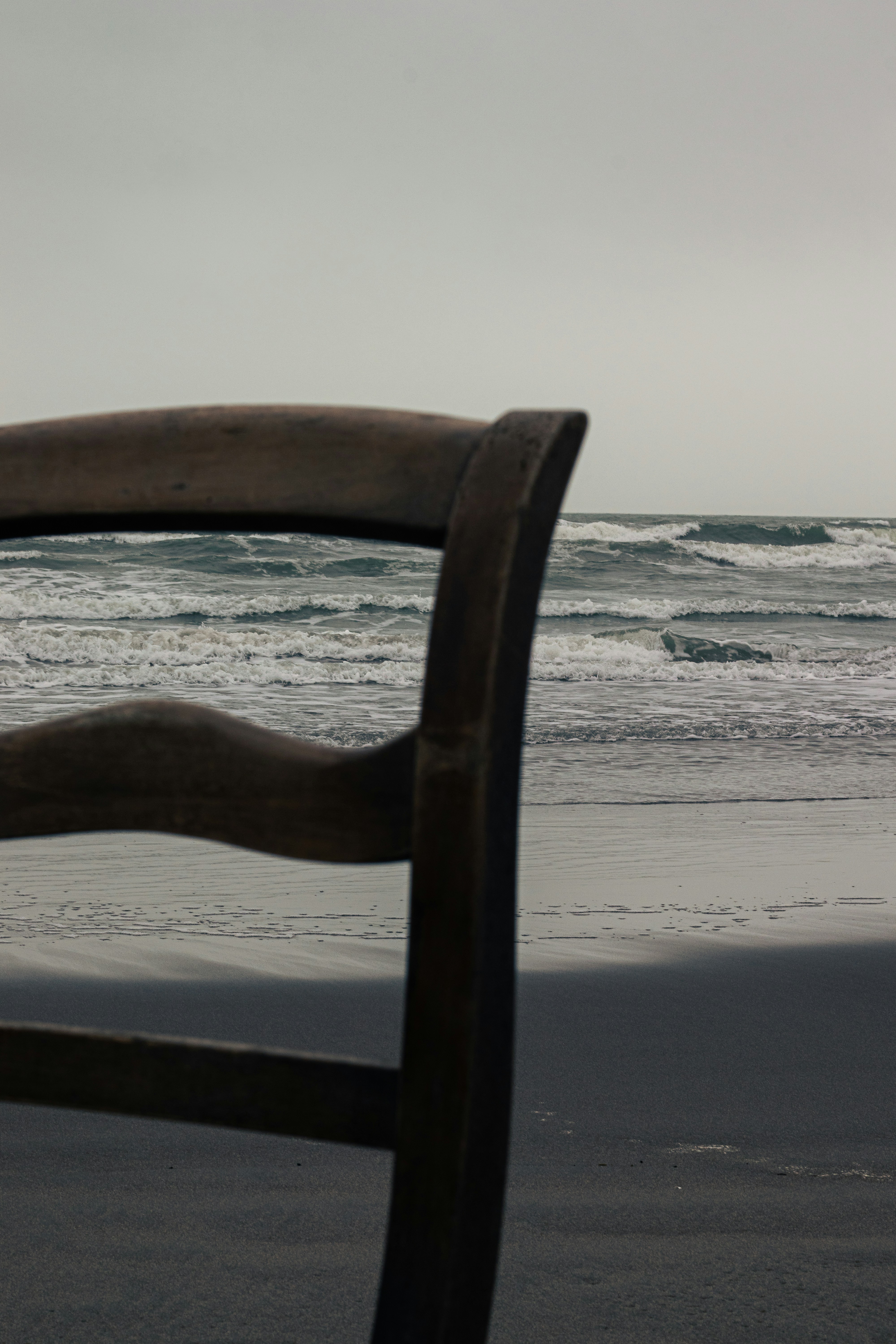 Left-Frame Weathered Chair Framing a Quiet Seascape