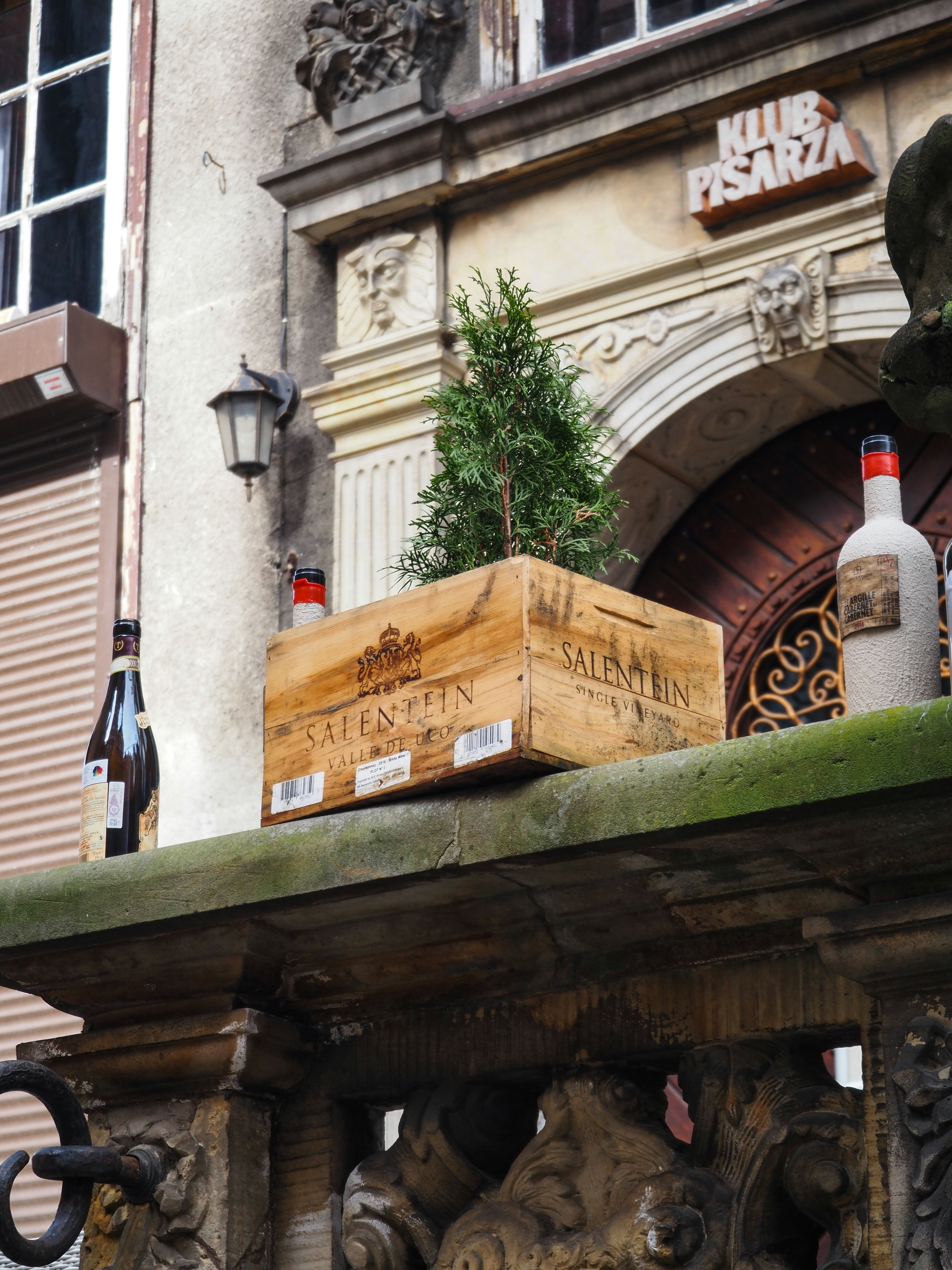 Wooden Crate with greenery atop a historic fountain