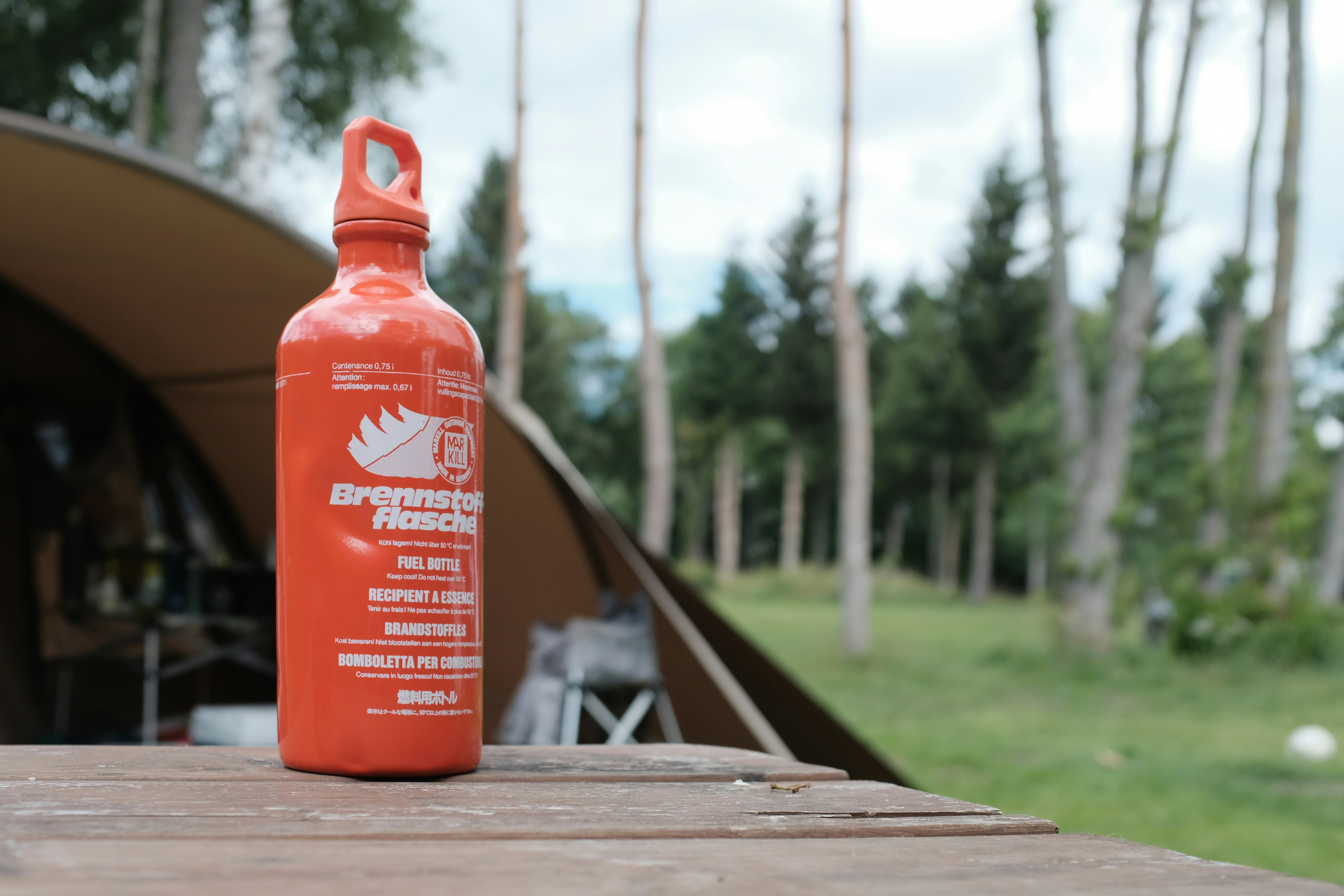A red fire extinguisher bottle sitting on a picnic table photo – Free ...