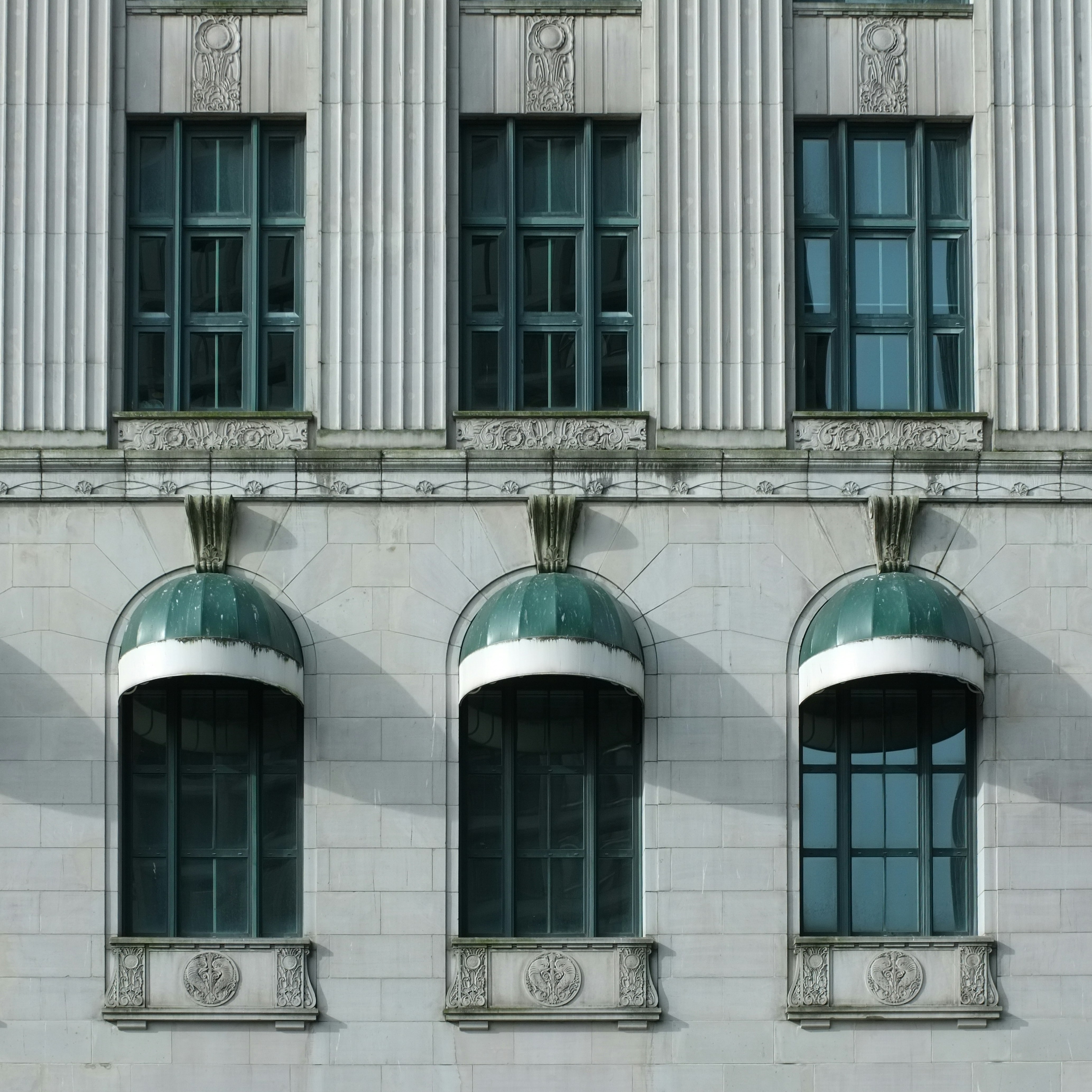Triple Arched Facade: Green Canopies Framing a Classical Rhythm