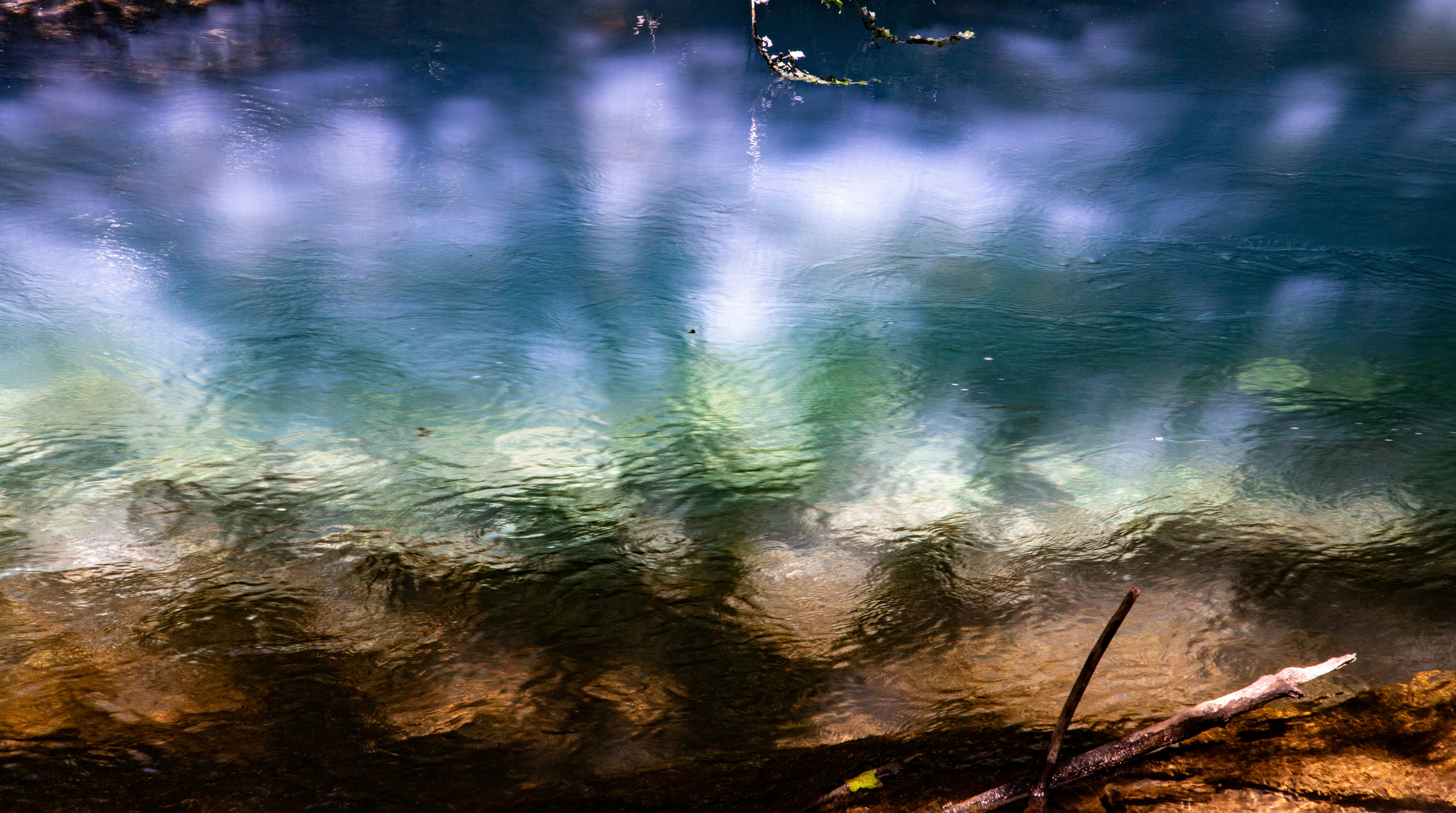 The enchanting blue hue of Río Celeste, located in the Tenorio Volcano National Park of Costa Rica, has long captivated visitors and scientists alike. It has been determined that the blue color is not due to a chemical composition but rather an optical illusion. When the two clear streams of Quebrada Agria and Río Buenavista converge at a point known as Teñidero, a physical reaction occurs. The riverbed's rocks are coated with a particular mineral composed of aluminum, silicon, and oxygen. These particles, specifically when they are around 566 nanometers in size, scatter sunlight in blue.