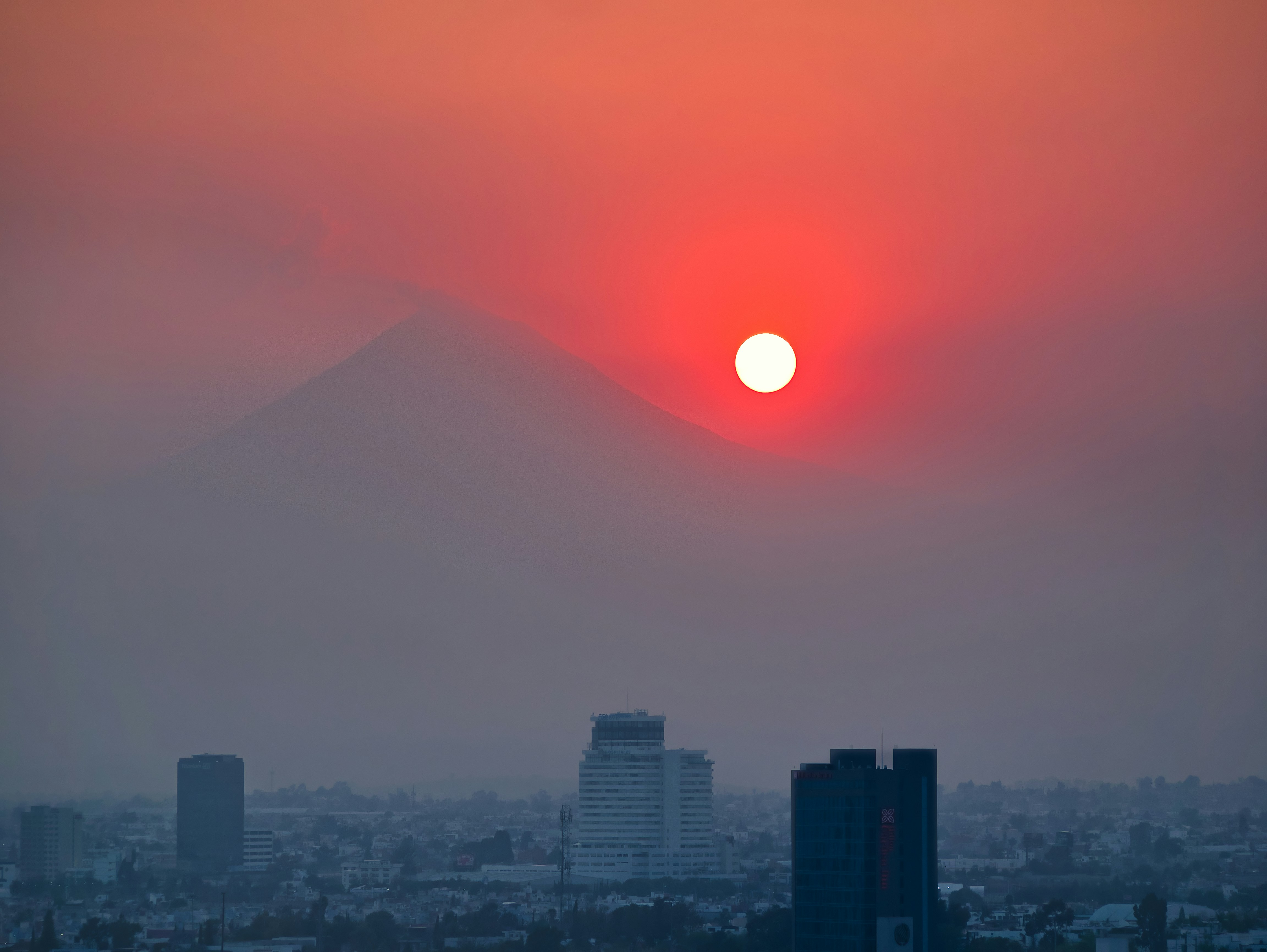 The sun is setting over a city with tall buildings photo – Free Urban ...