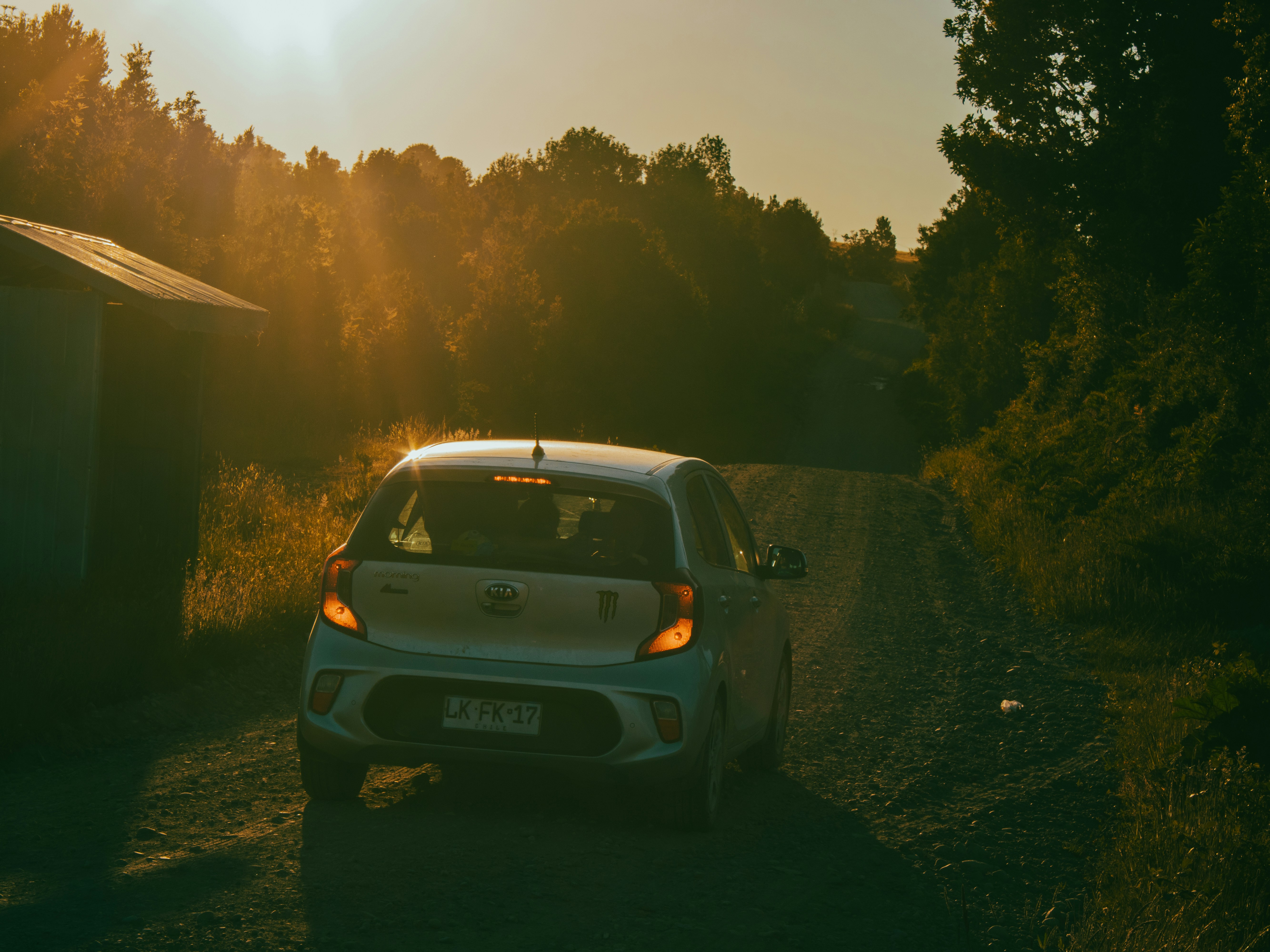 a white car driving down a dirt road