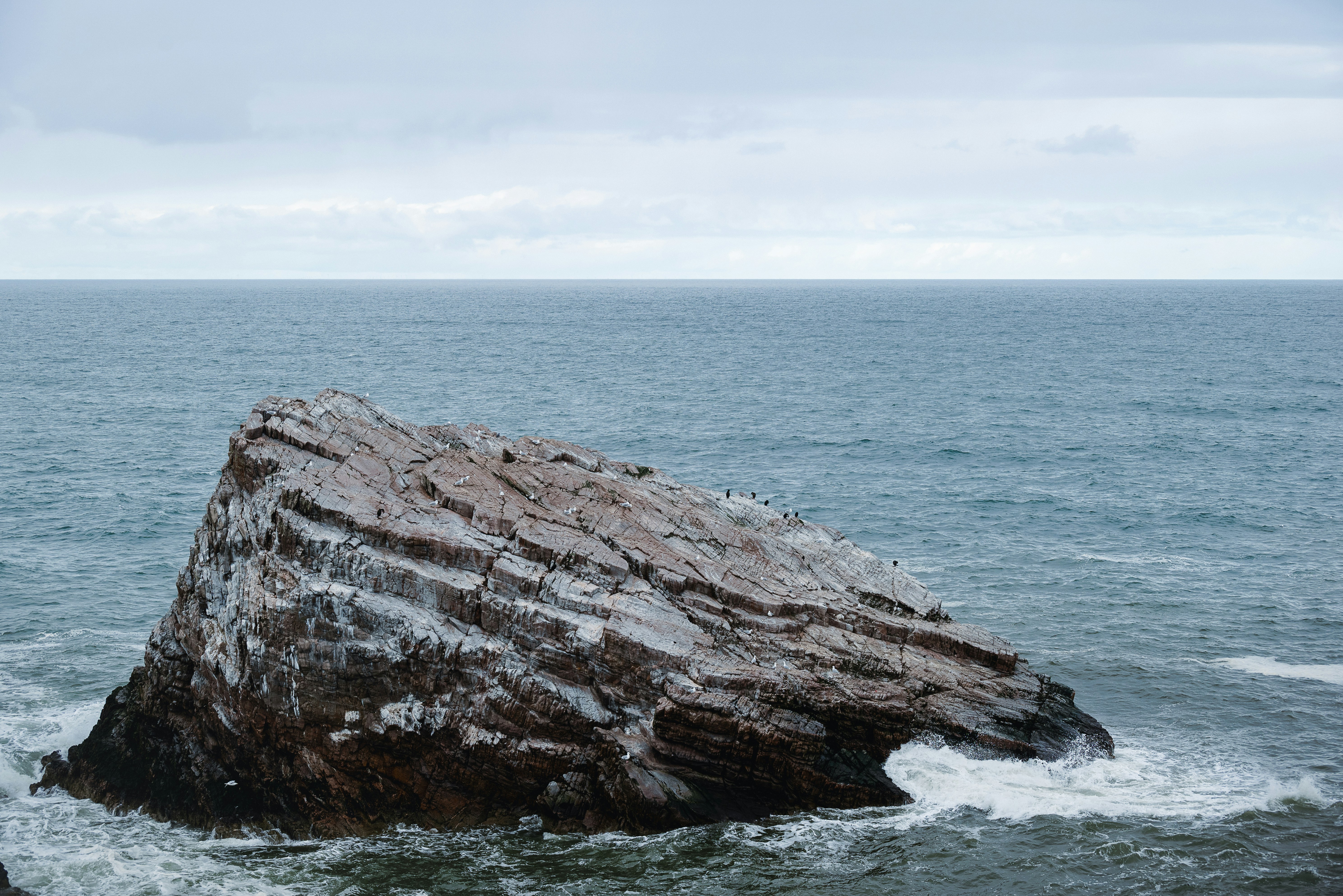 Uma grande rocha saindo do oceano foto – Imagem grátis sobre Papel de ...