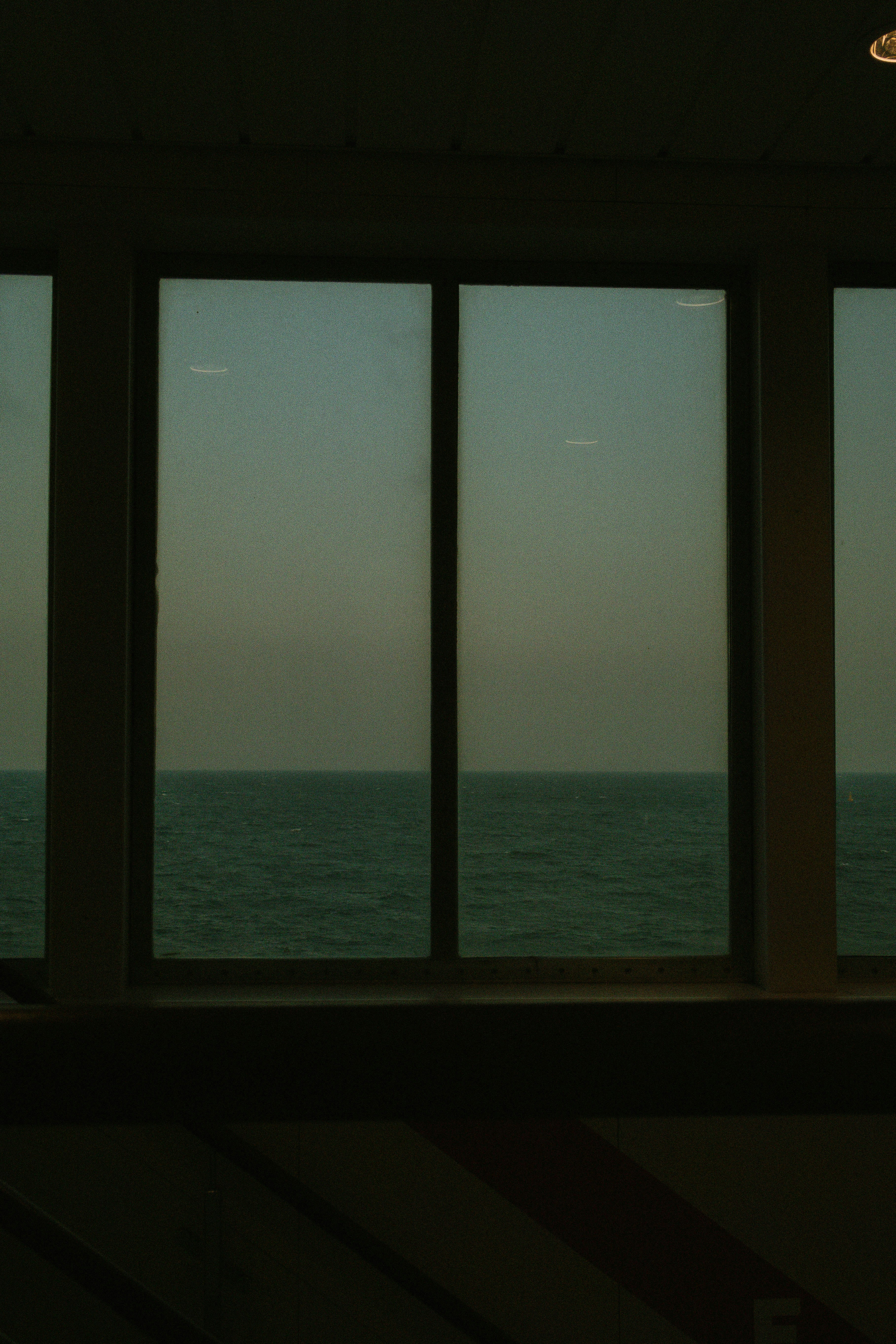 Framed Horizon: Sea Viewed Through a Trio of Window Panes