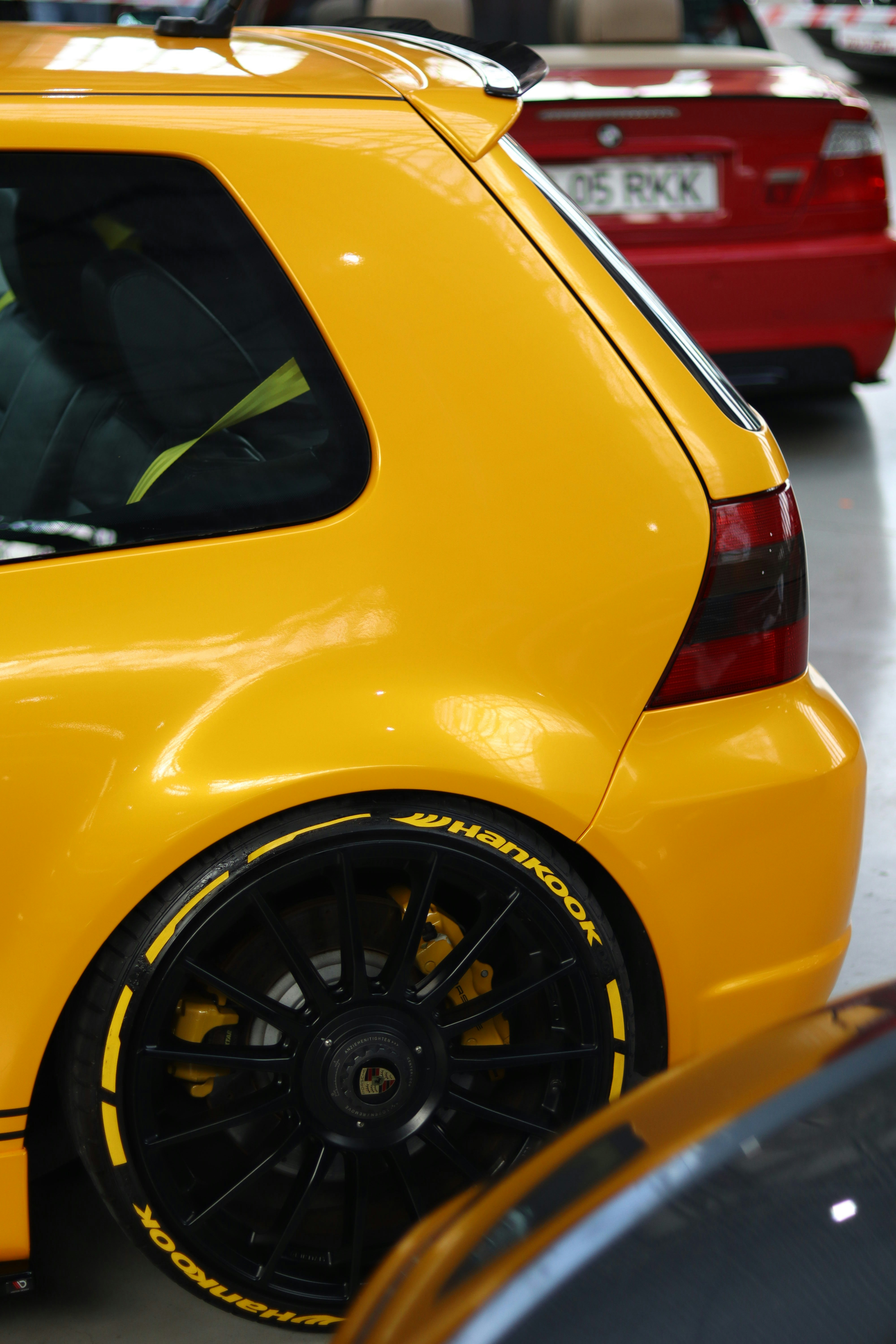 Shimmering yellow Porsche rear quarter with a race-ready black wheel and Hankook tire
