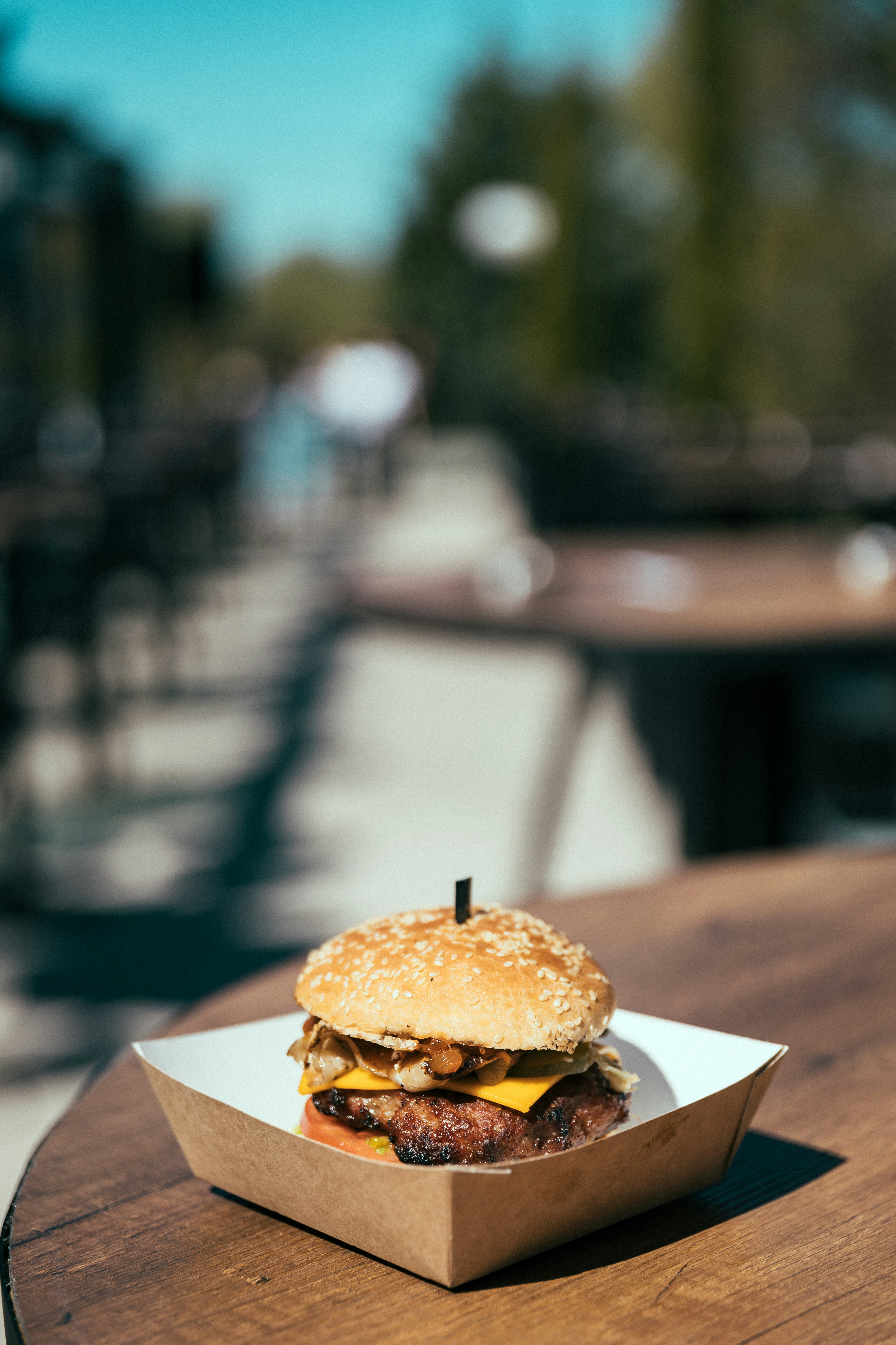 Sunlit Patio Cheeseburger on a Weathered Wooden Table