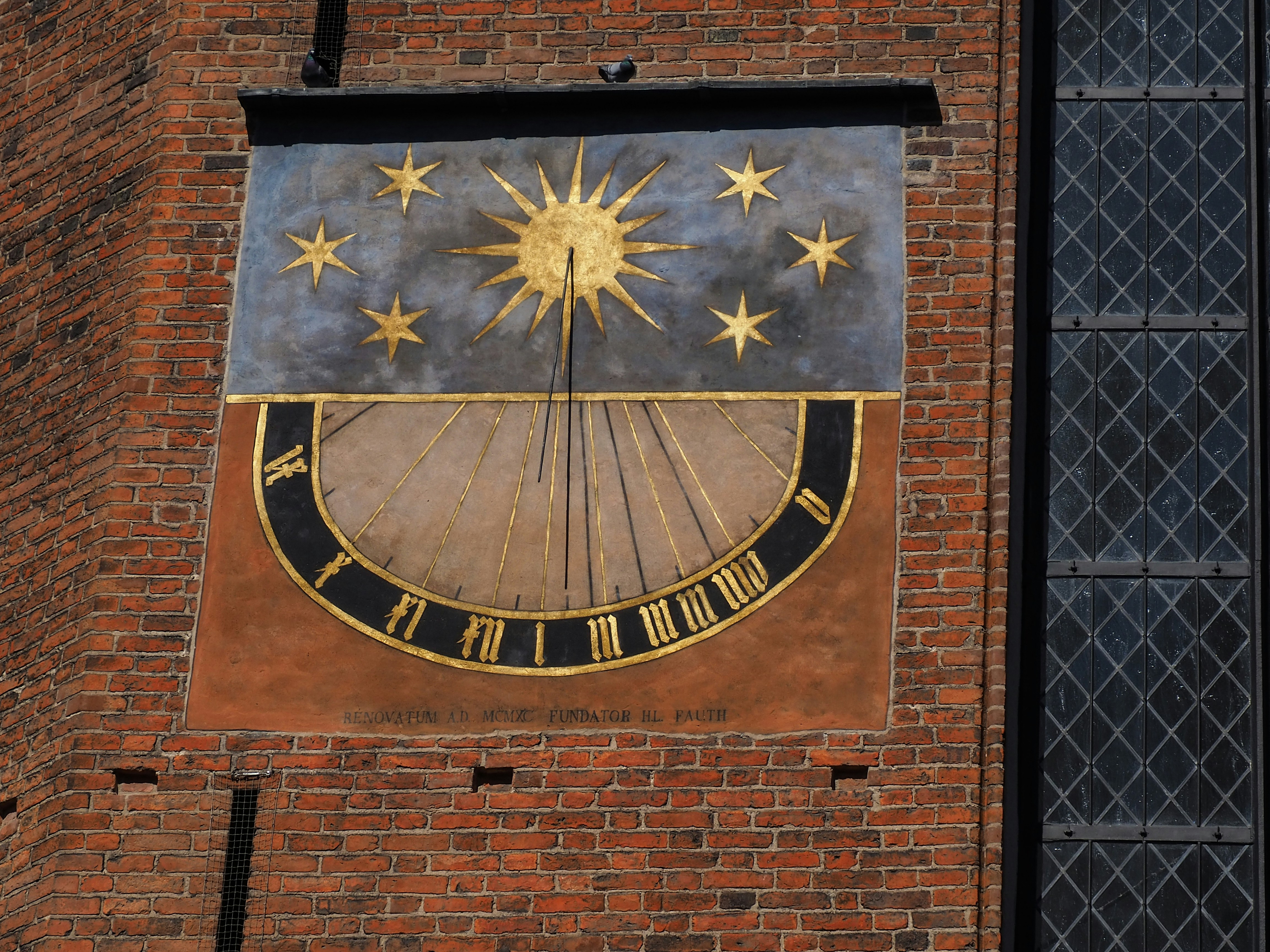 Sunburst Sundial Mural on Weathered Brick Facade