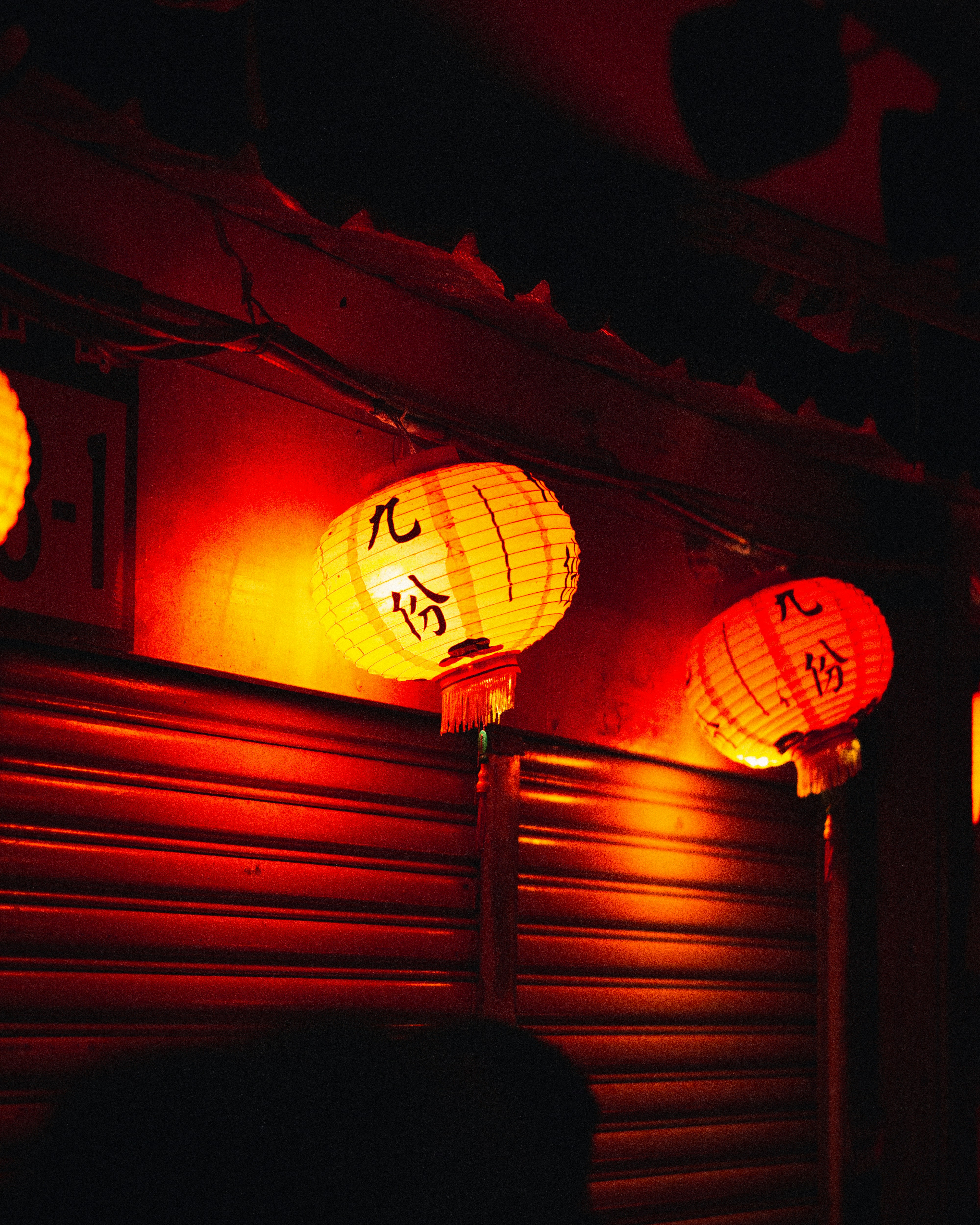 three chinese lanterns lit up in the dark
