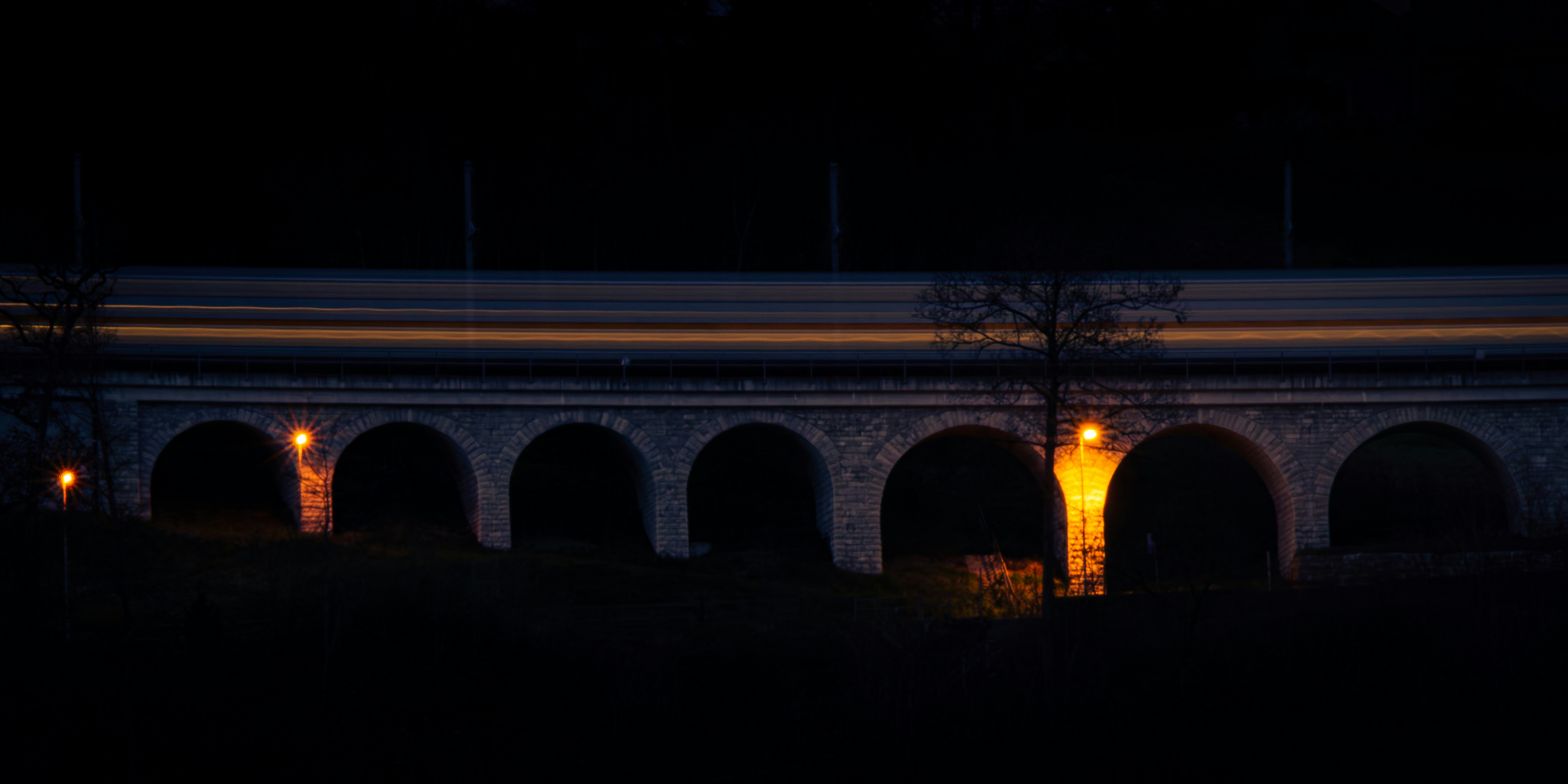 Moonlit Viaduct: Glowing Arches Under Night Sky