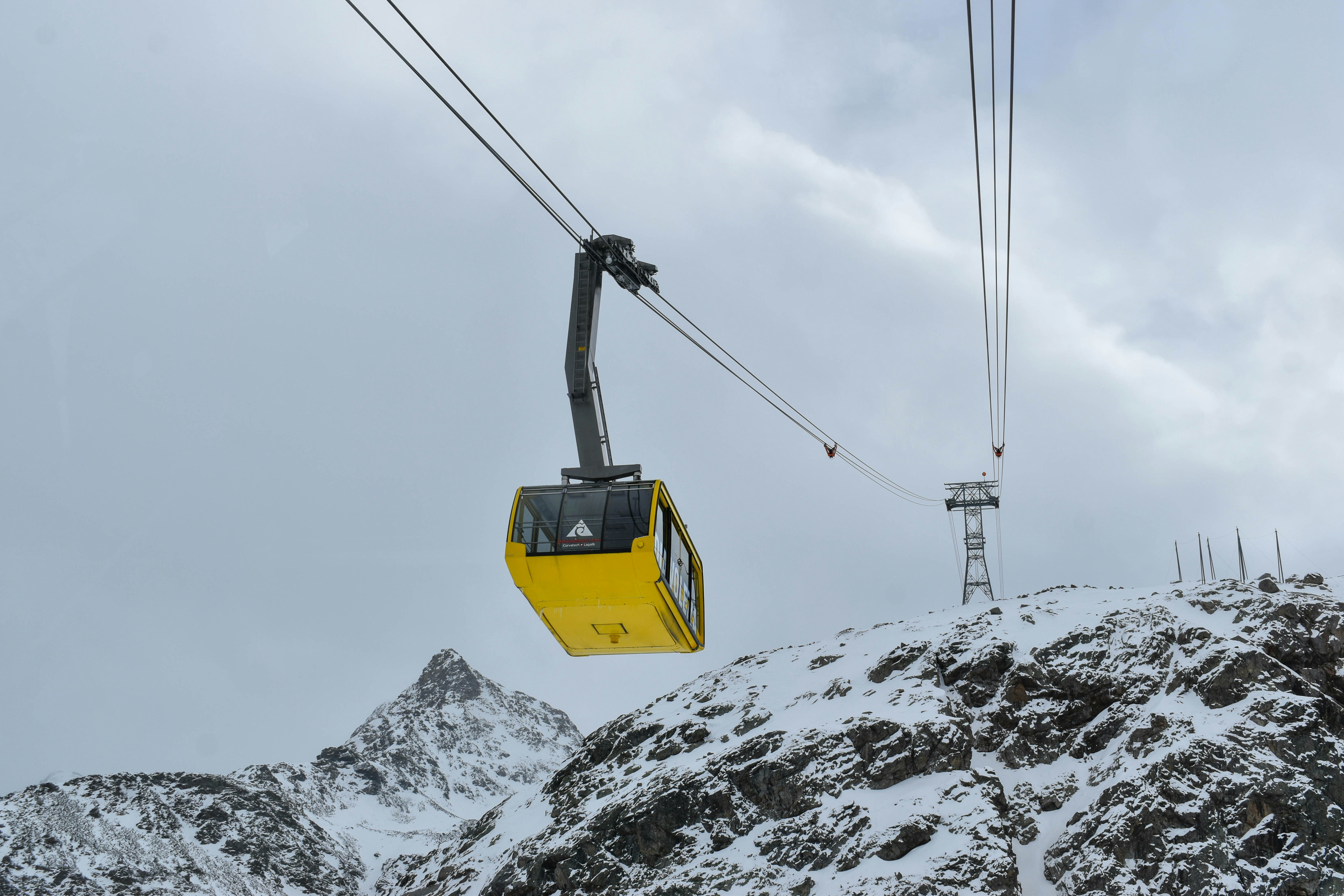 Yellow Cable Car Drifts Over Frosted Alpine Peaks