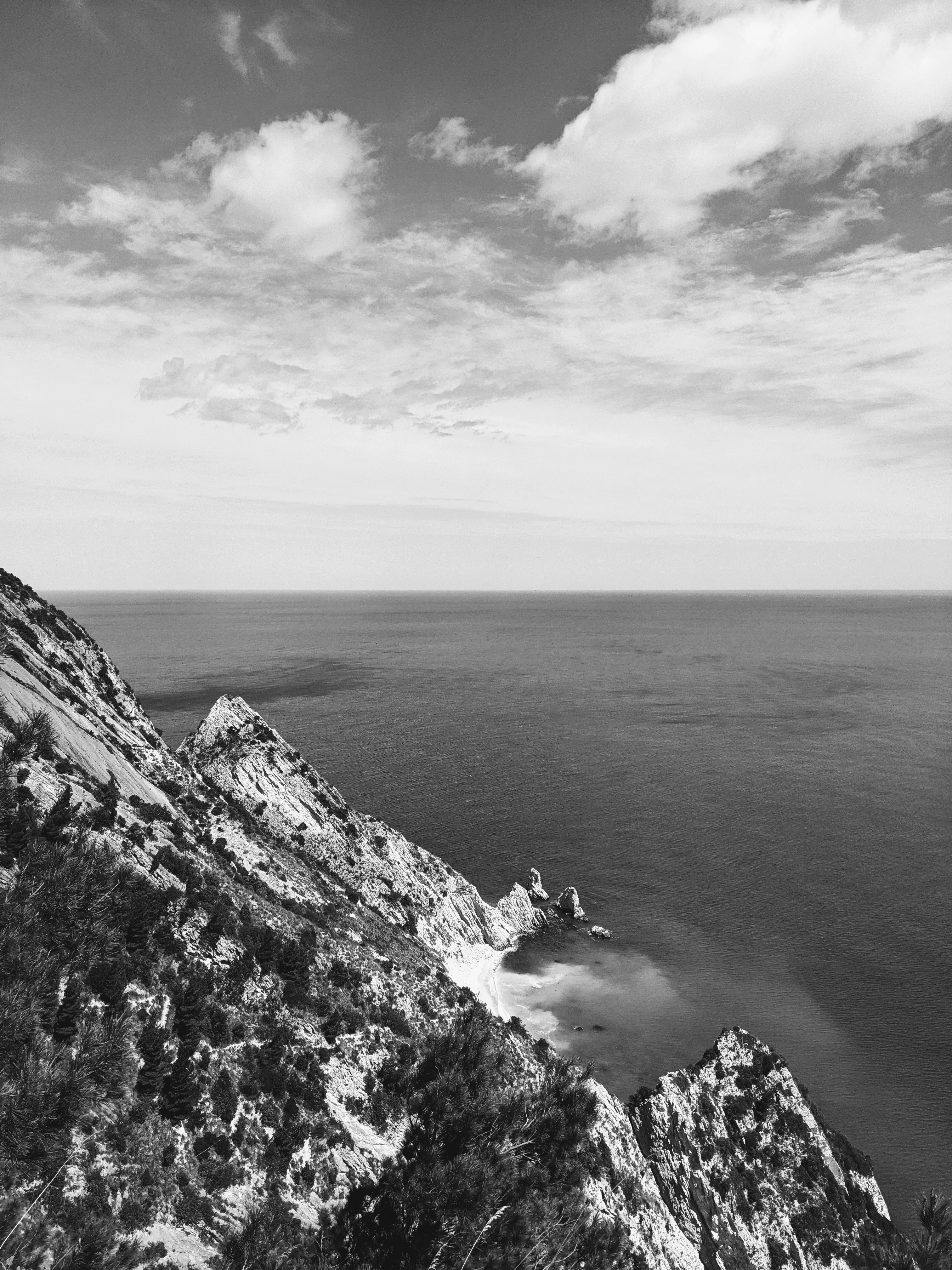 A black and white photo of a cliff overlooking the ocean photo – Free ...