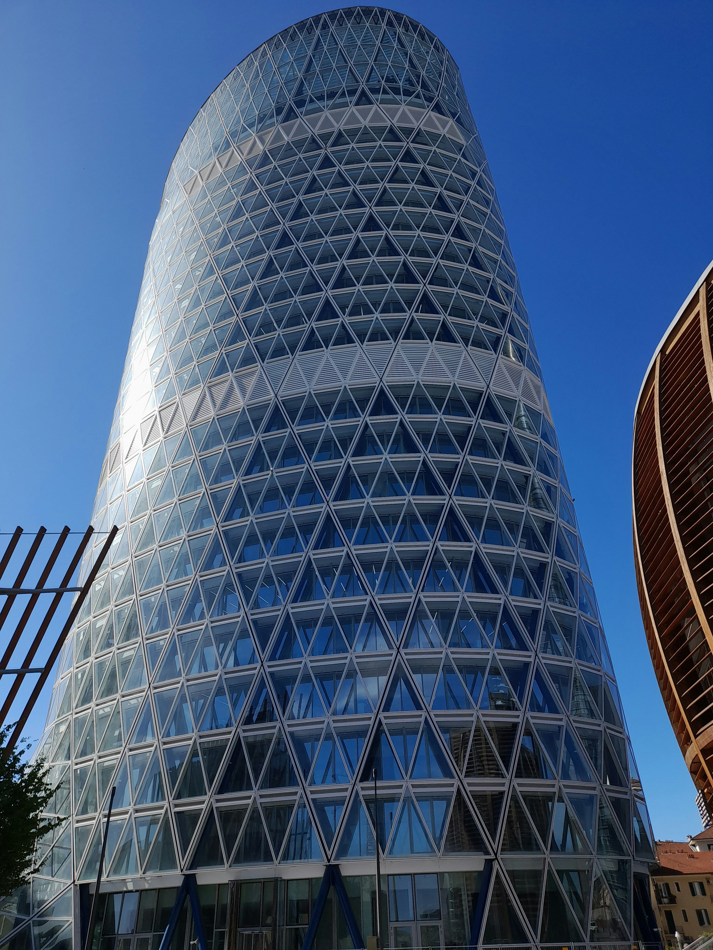 Diamond-grid Cylinder Rising Against a Clear Blue Sky