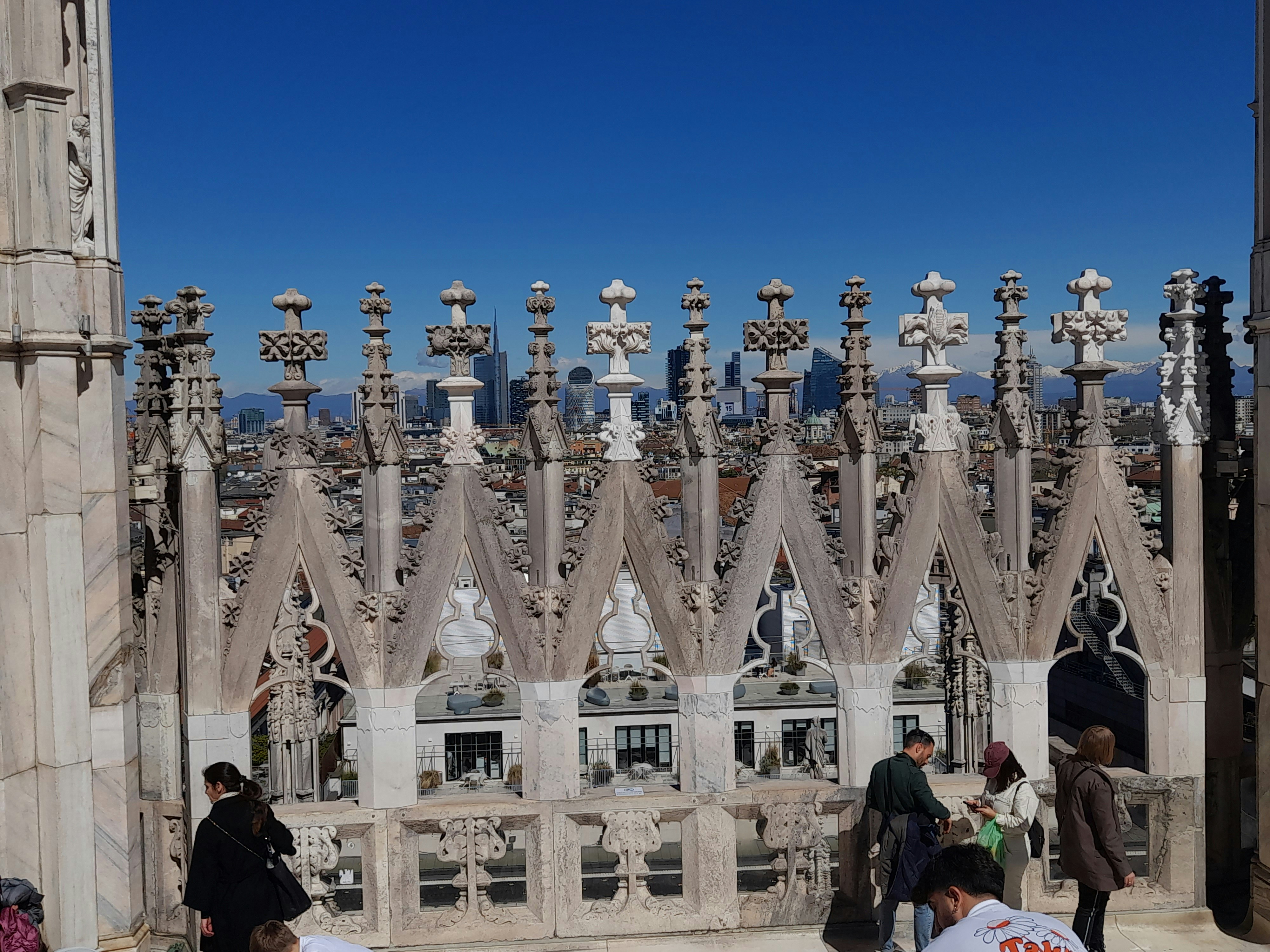 Stone Lattice Overlook: Visitors Amid the Gothic Roofscape