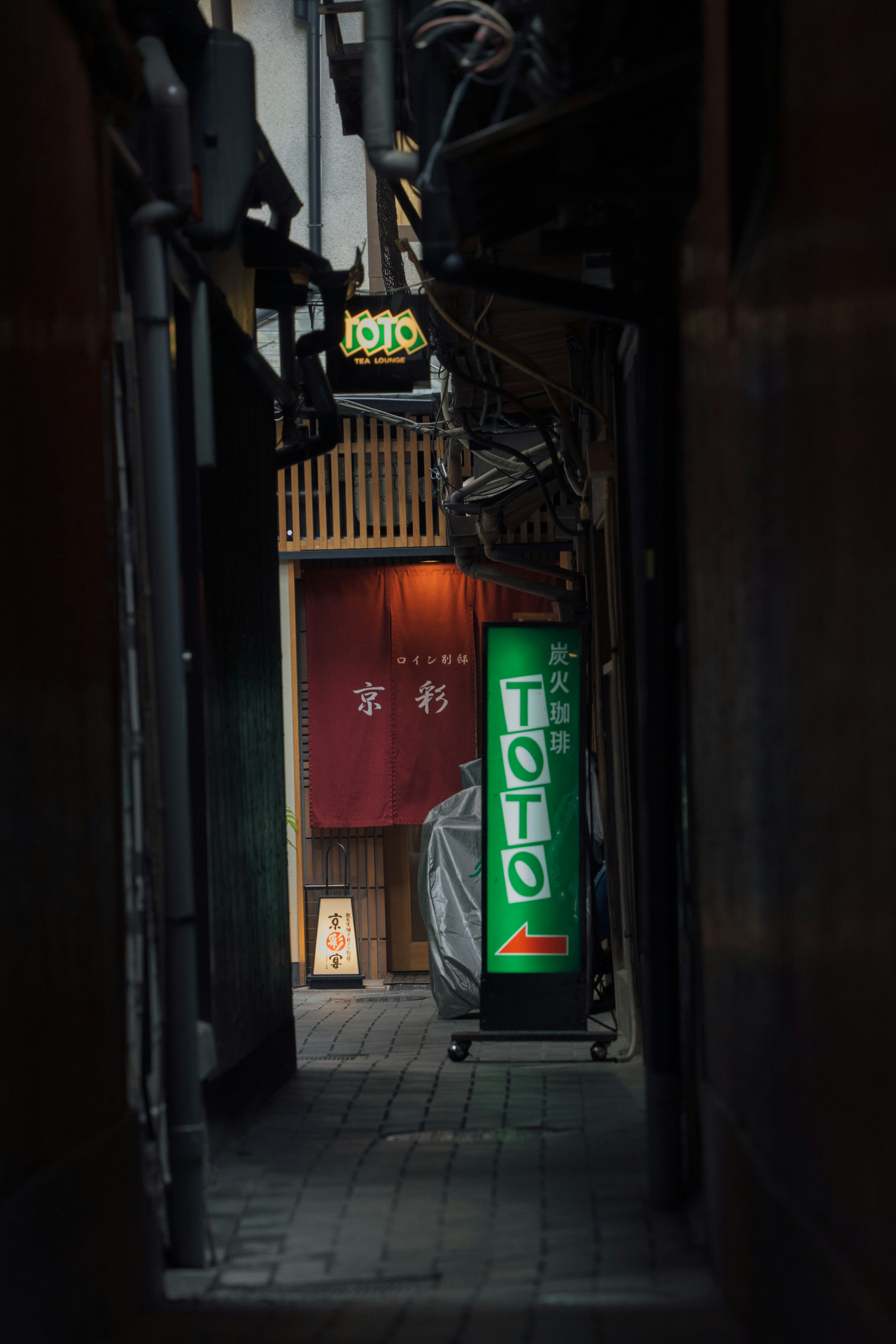Emerald Signpost Illuminates a Narrow Japanese Alley
