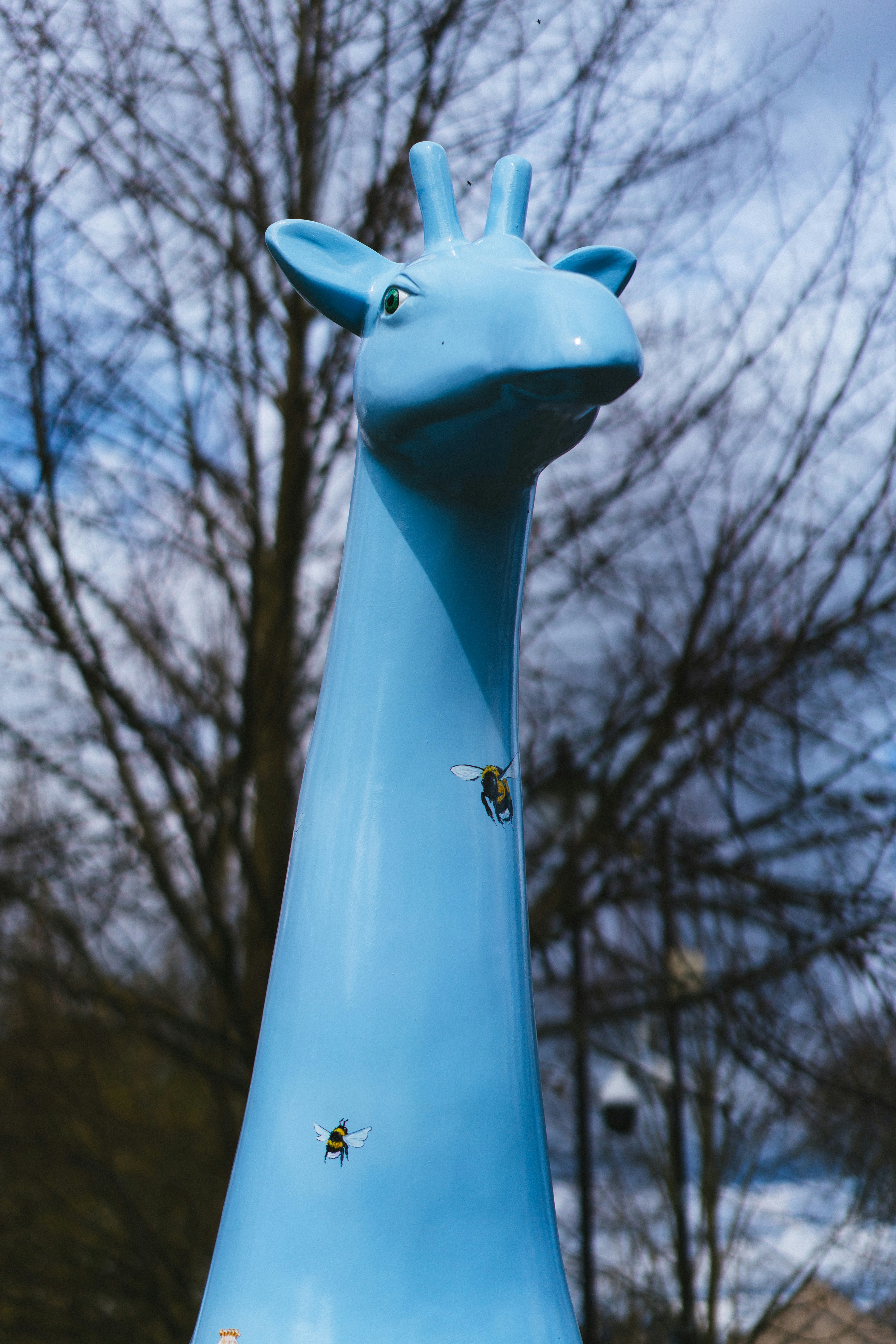 Blue Giant Giraffe at Dusk: A Playground Icon Against Tea-Blue Sky