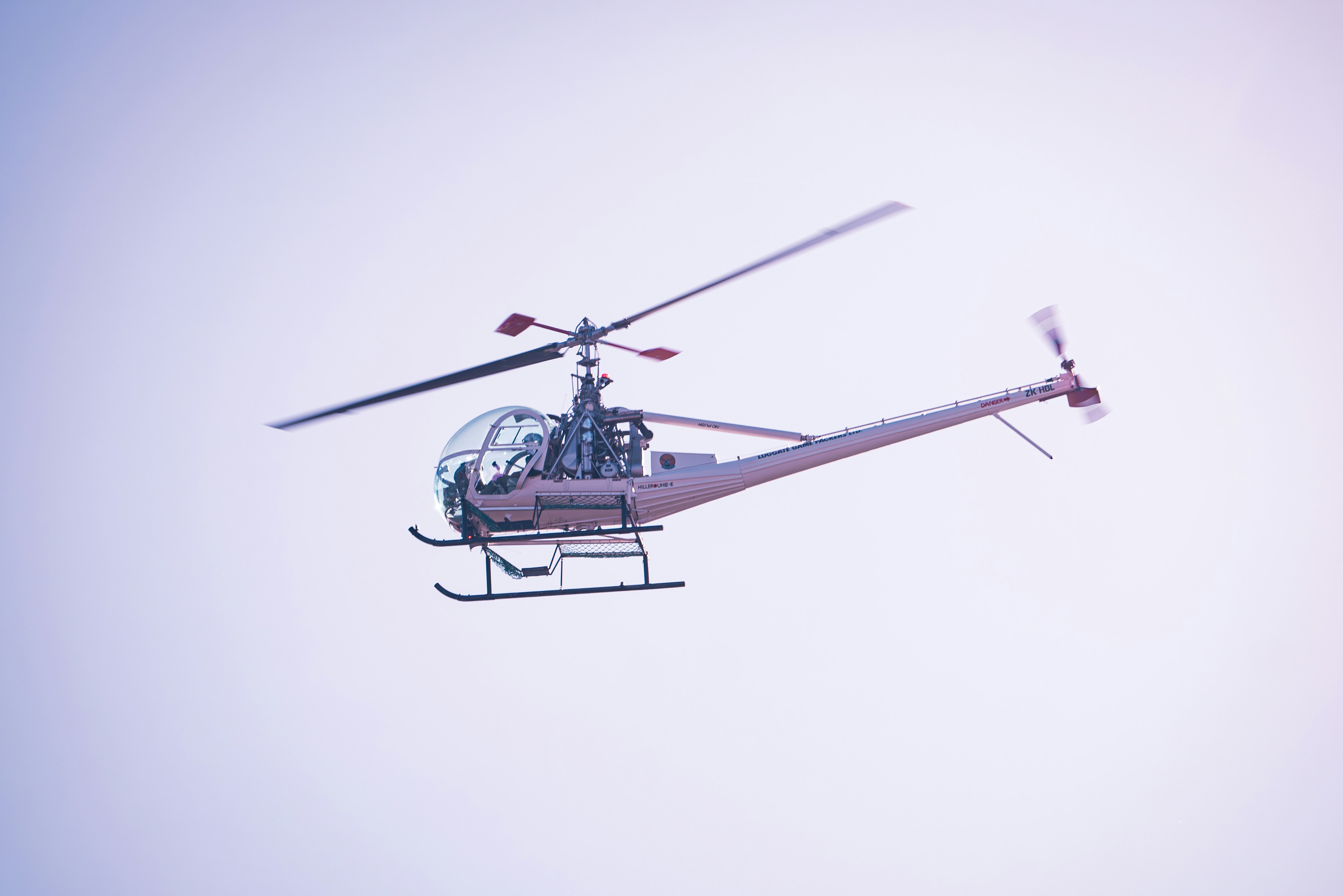 Midair Minimalism: A Compact Helicopter Drifts Across a Pale Sky