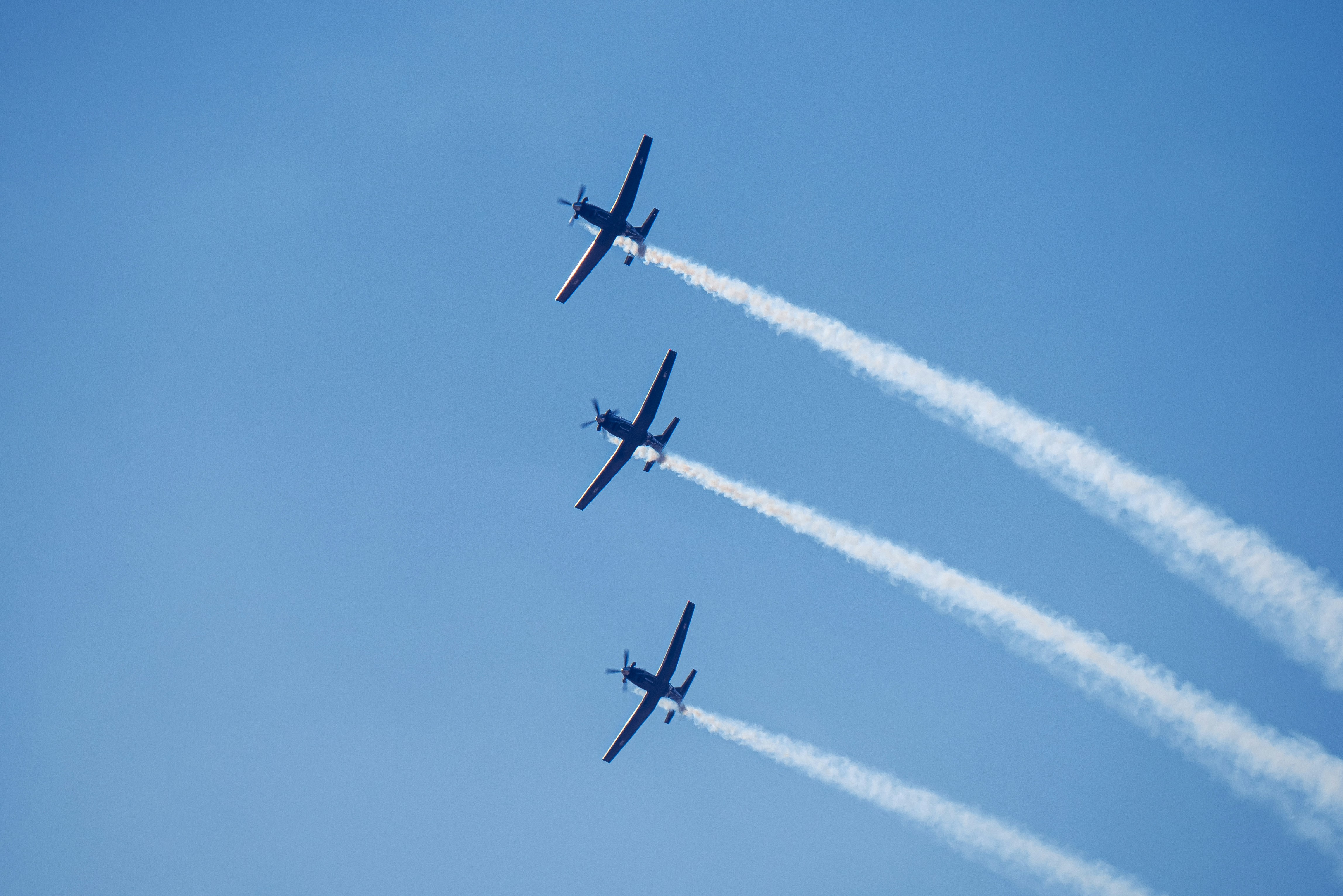 Three airplanes flying in the sky leaving a trail of smoke behind them ...