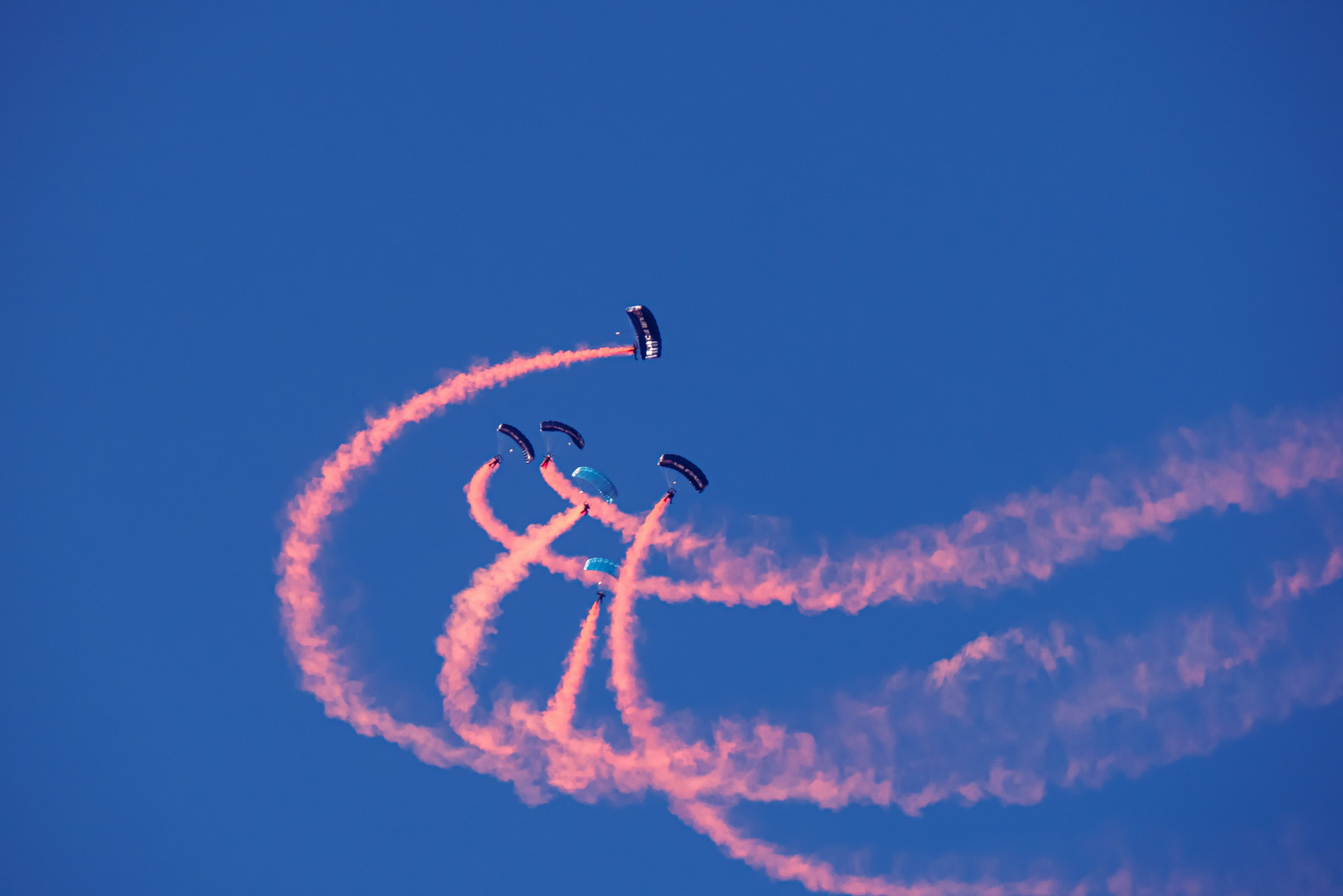 Echoes of Flight: Parachute Swirl Over a Cerulean Sky