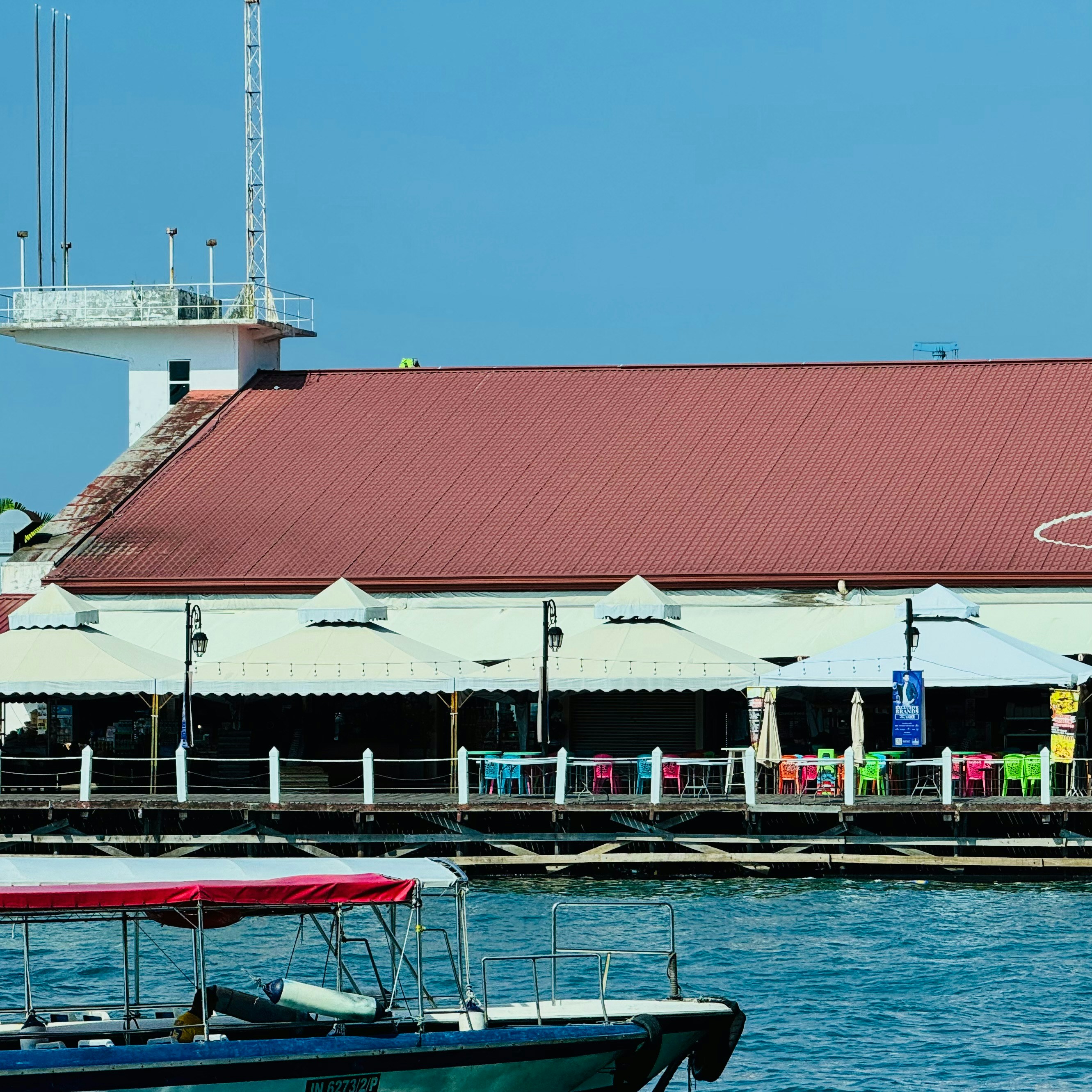 Umbrella-lined Harborfront Terrace Under a Red Roof
