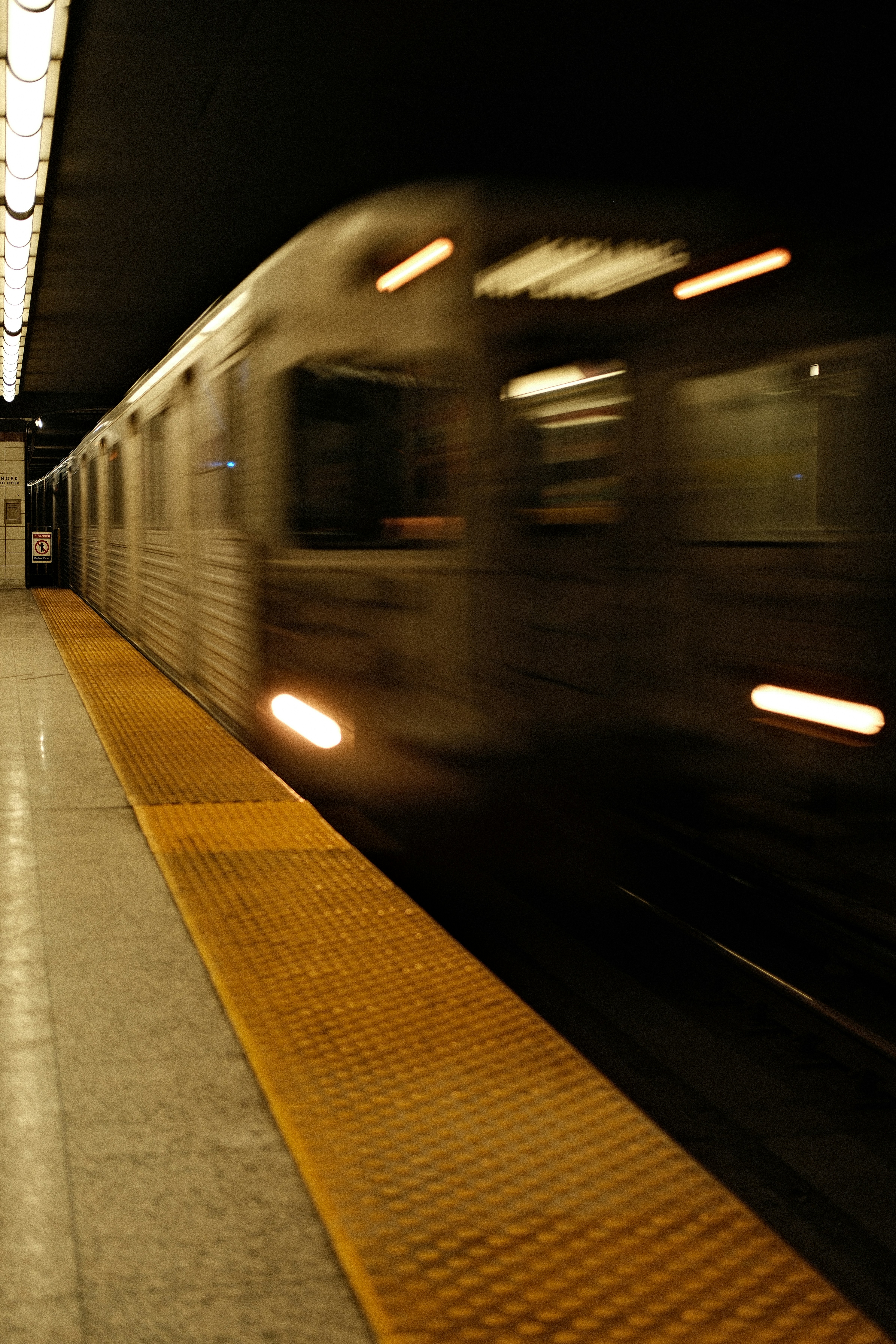 A subway train speeding past a platform at night photo – Free Toronto ...