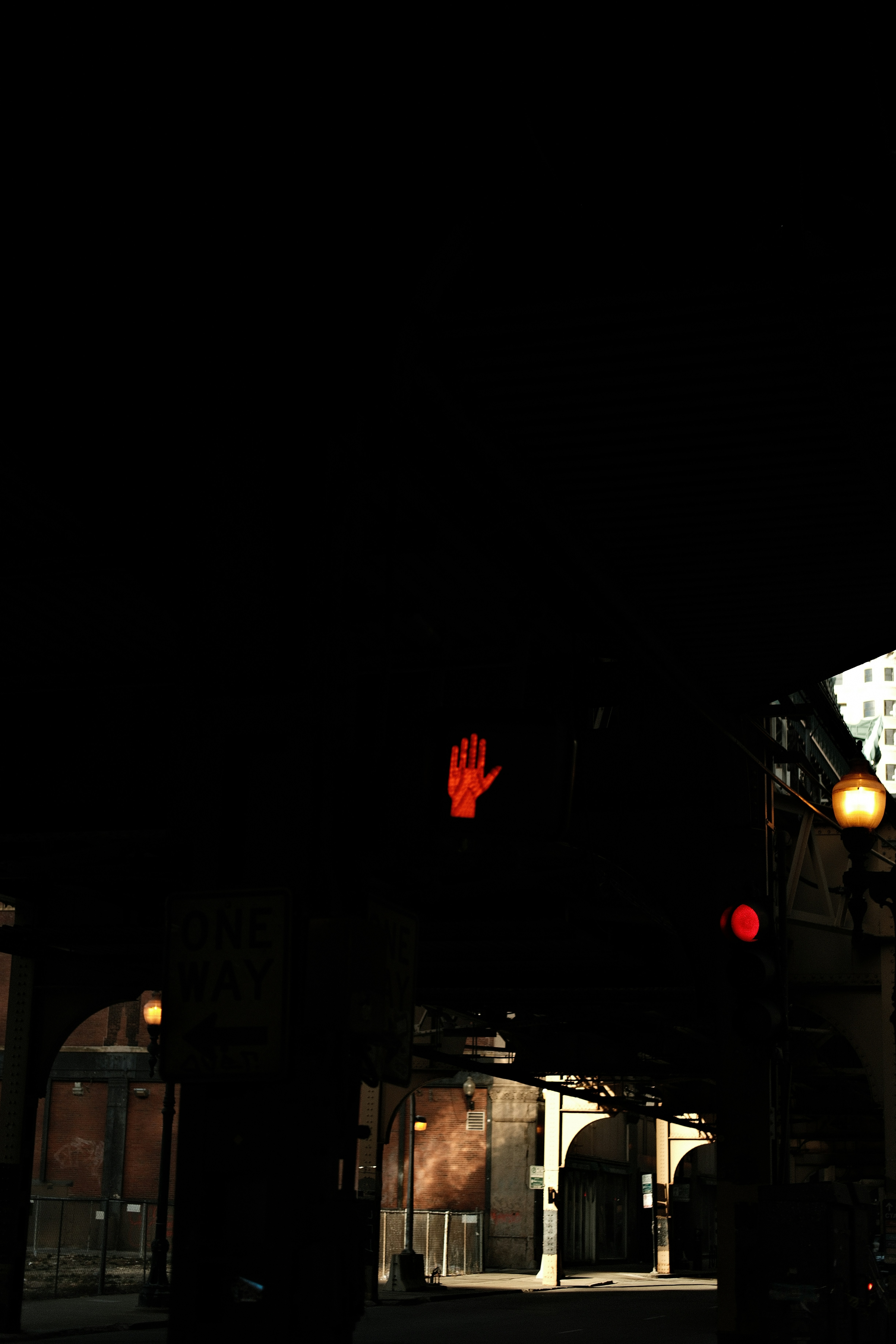 Underpass Neon Gesture: A Quiet Orange Hand in the City’s Shadow