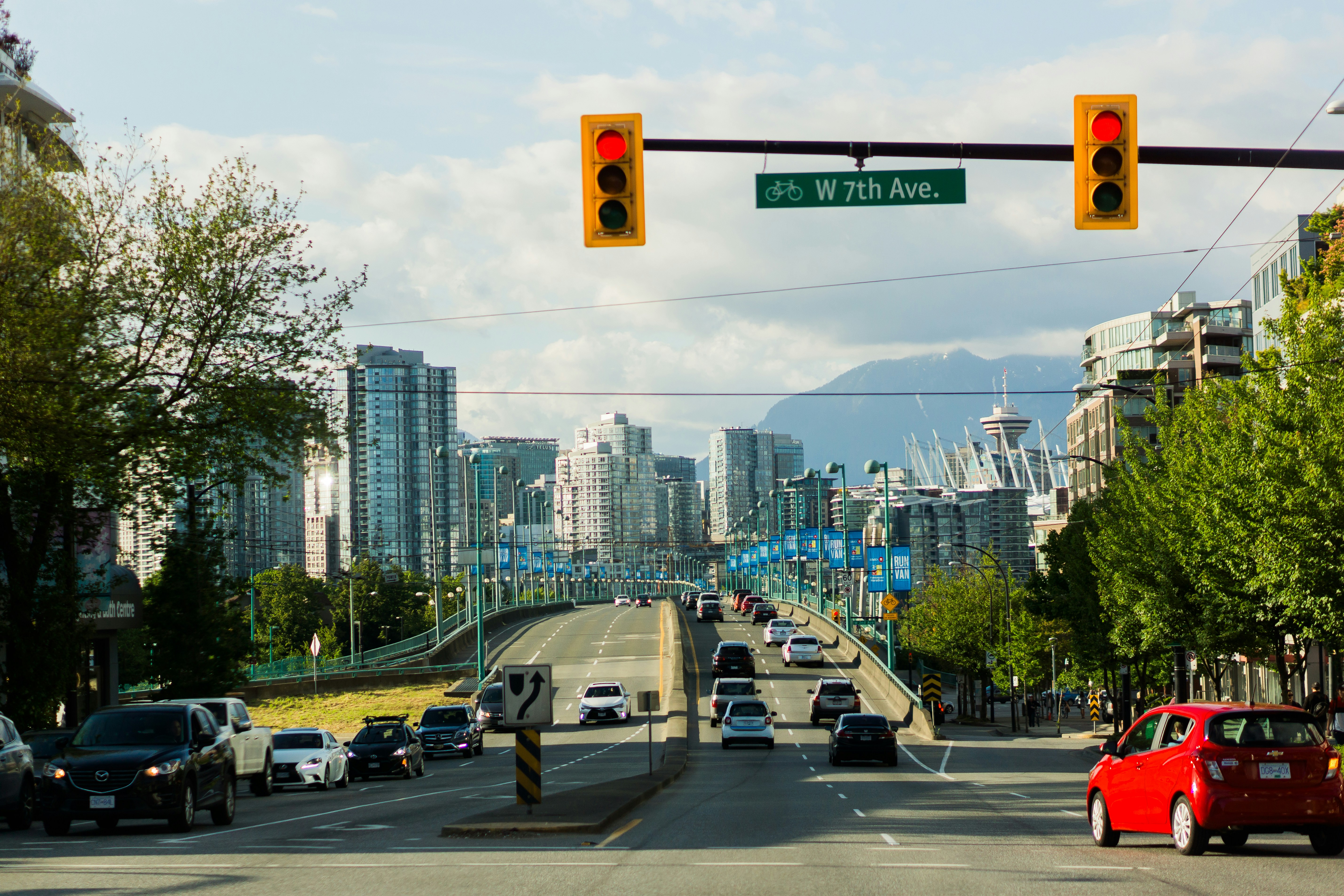 Convergence on W 7th Ave: Traffic, Glass Towers, and a Mountain Horizon