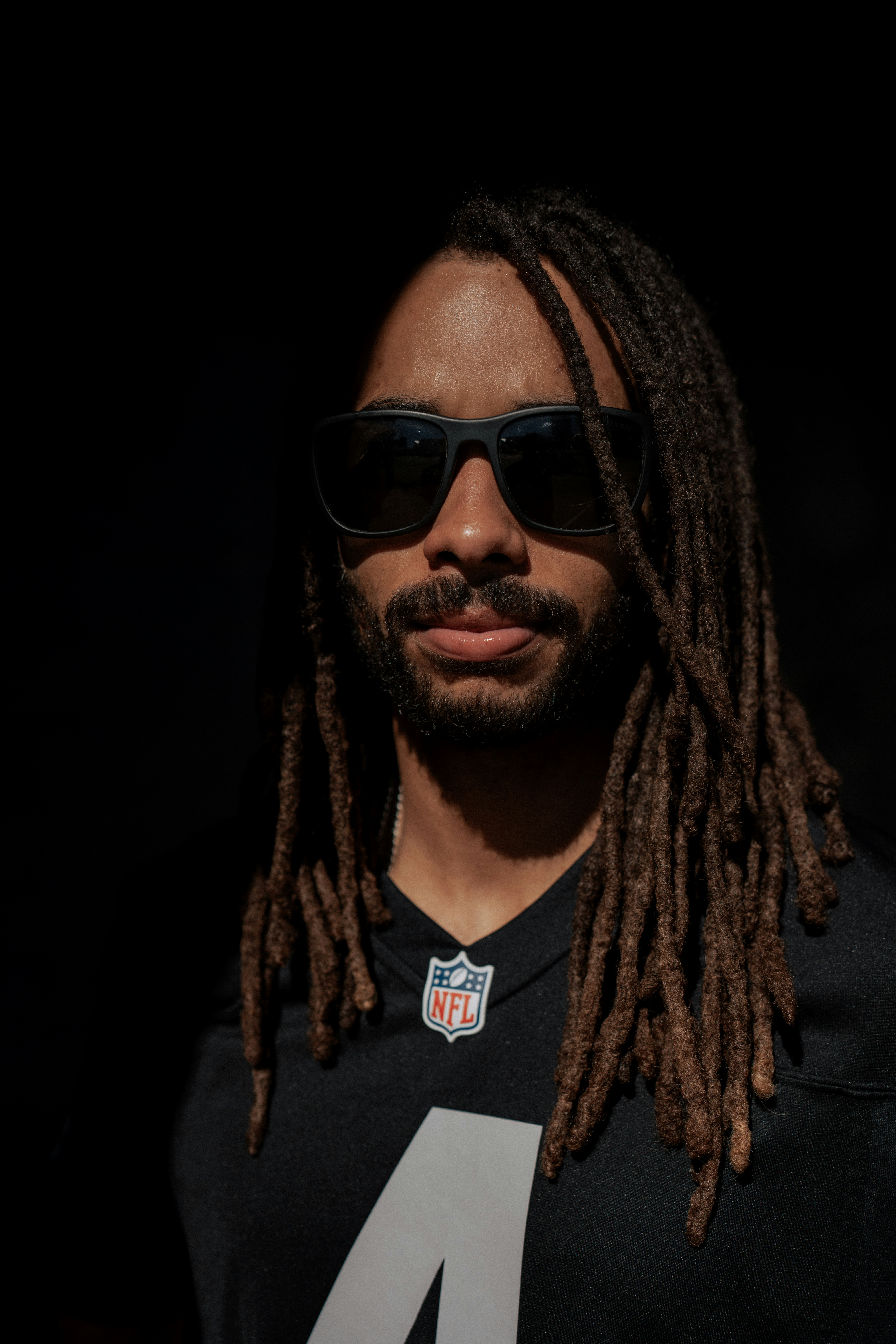 Noir Gridiron Portrait: Dreadlocks, Shades, and a Quiet NFL Presence
