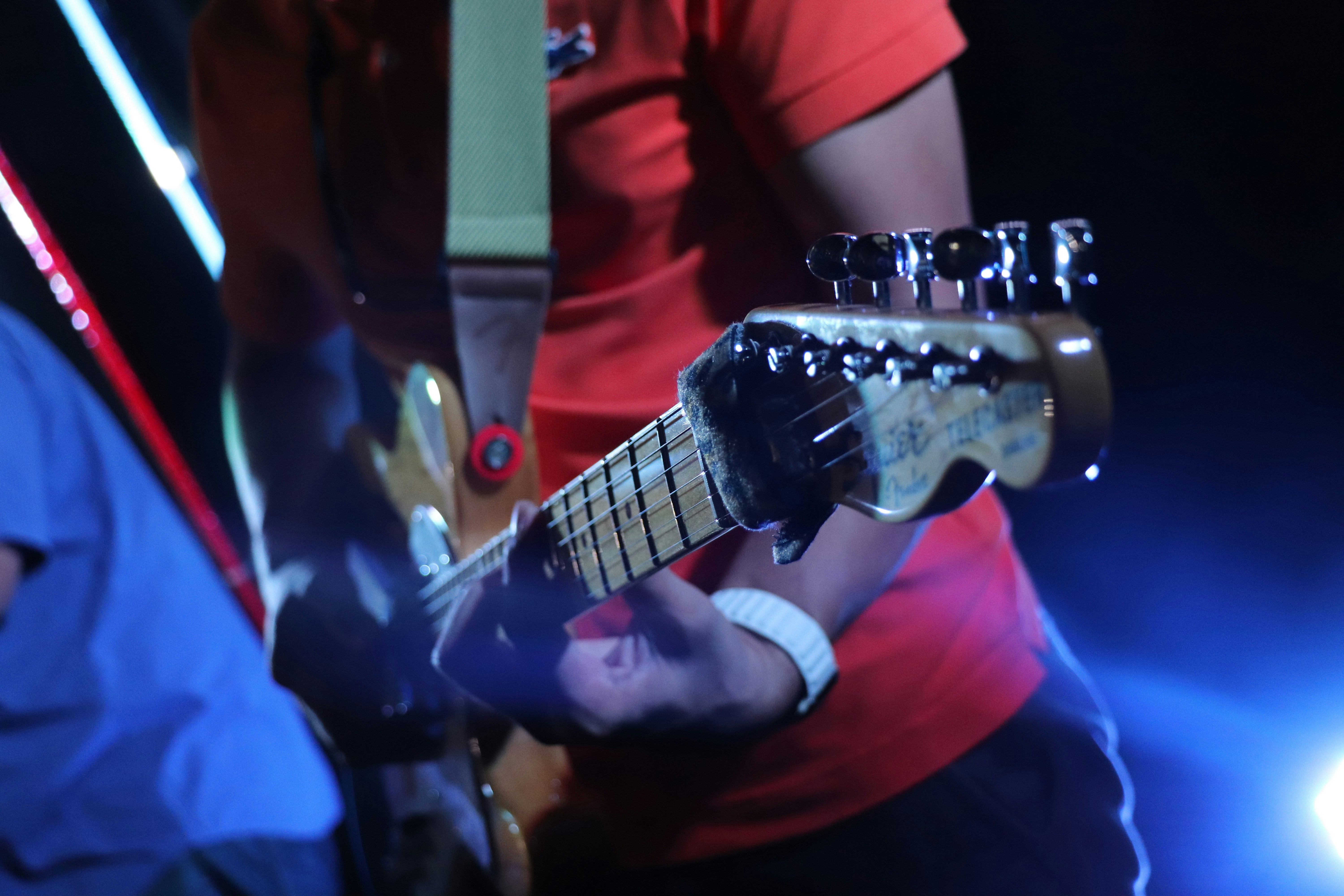 Guitarist in the Spotlight: Neck and Frets in Neon Blues