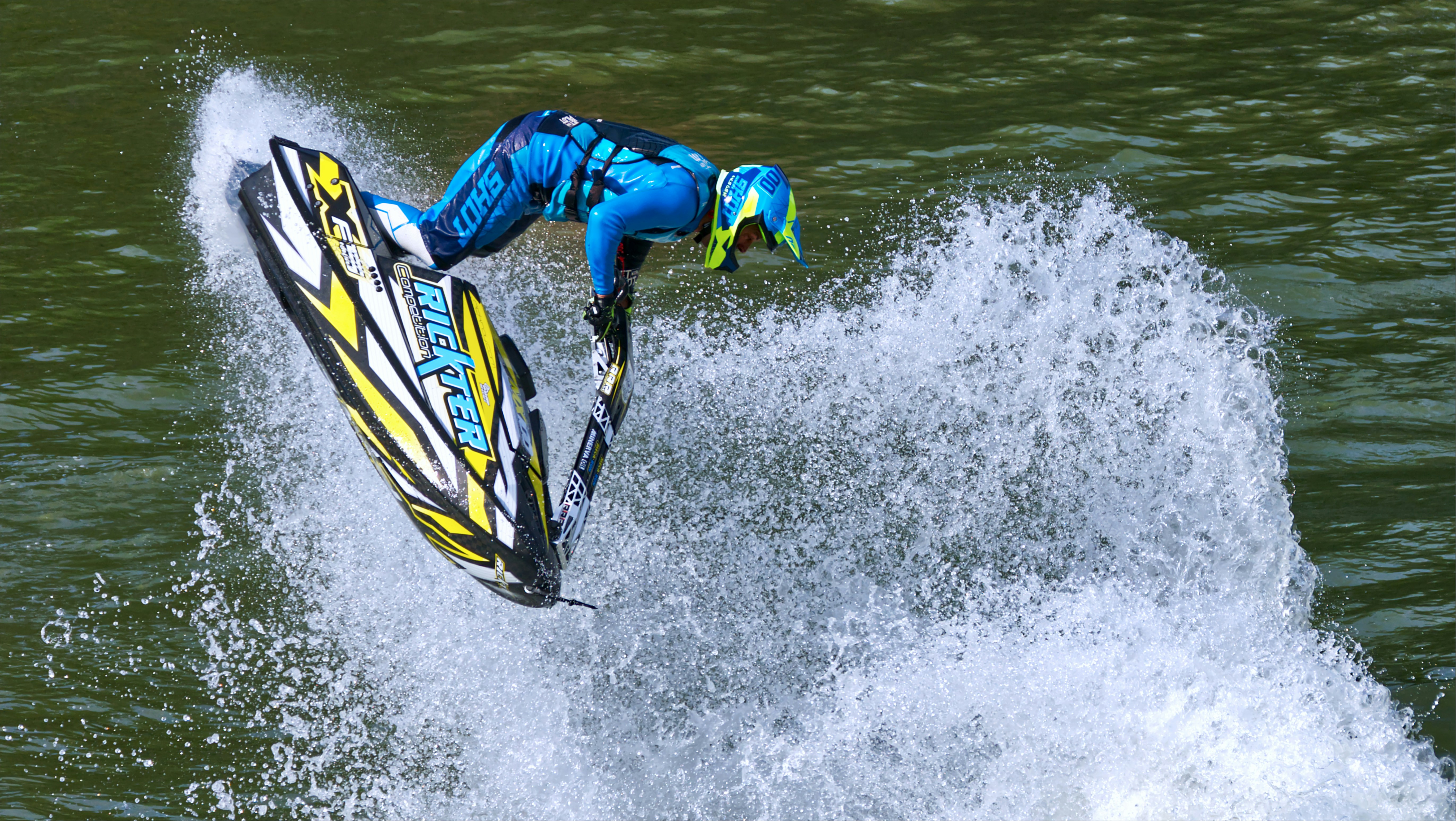 Blue-Suited Rider Breaks the Crest: Jet-Ski Aerial Above Turbulent Spray
