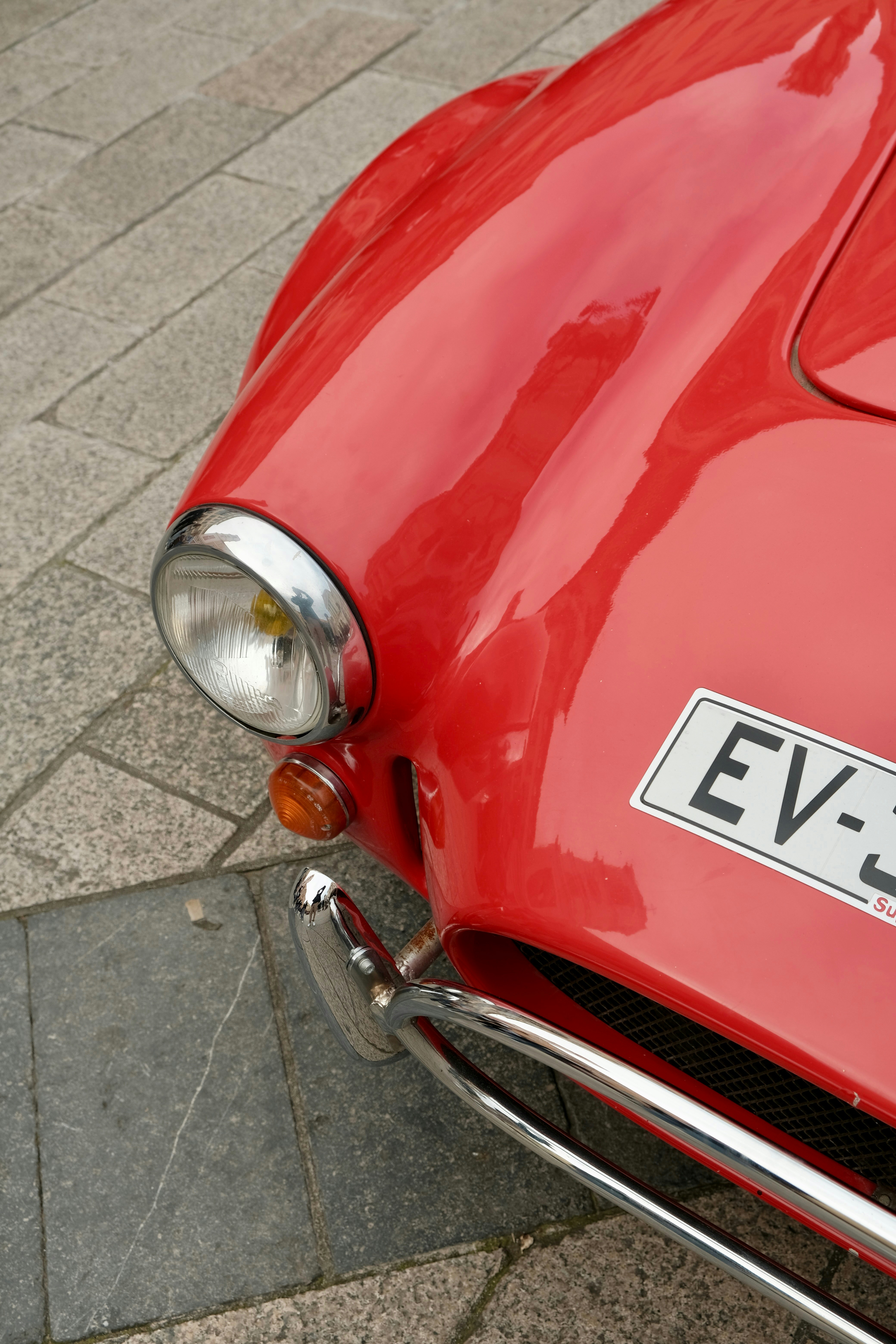 Crimson Curves and Chrome: A Vintage Car's Headlamp Portrait