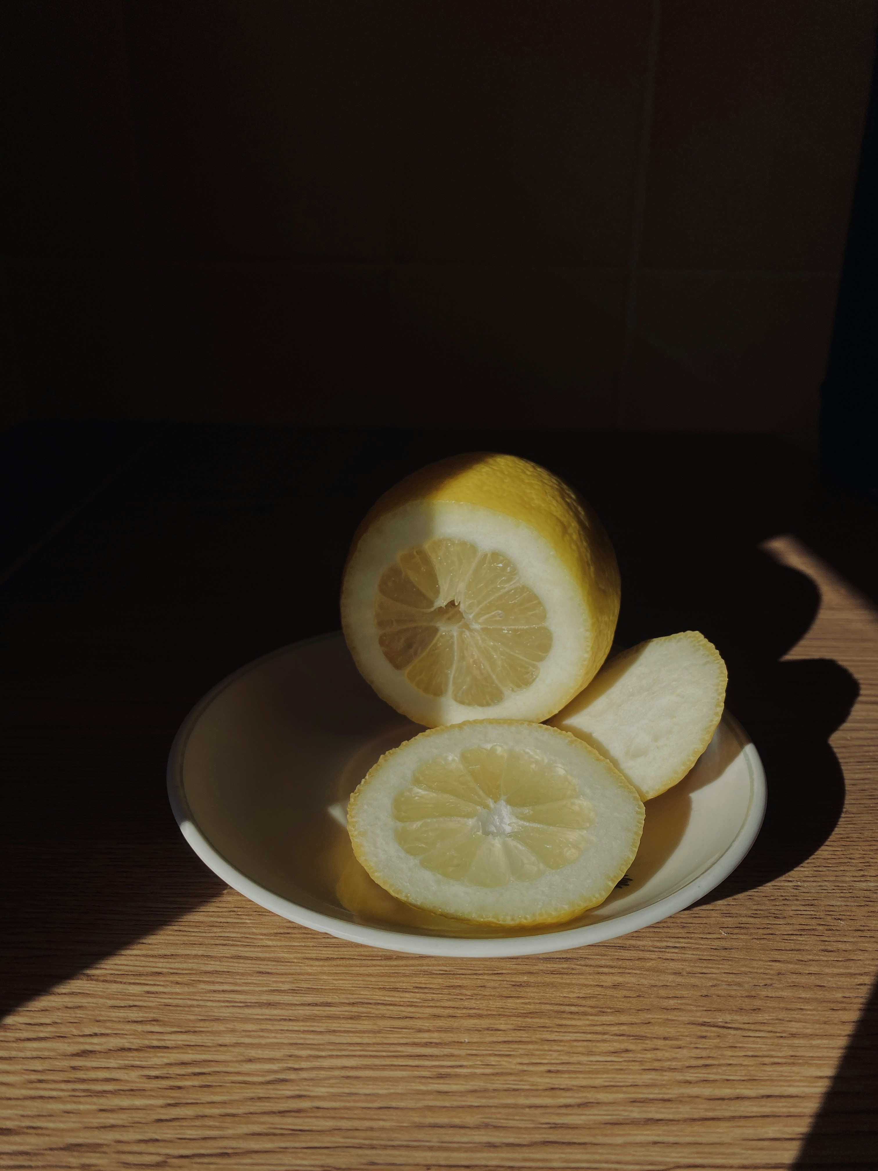 Lemon Halves Under a Narrow Spotlight on a Wooden Table