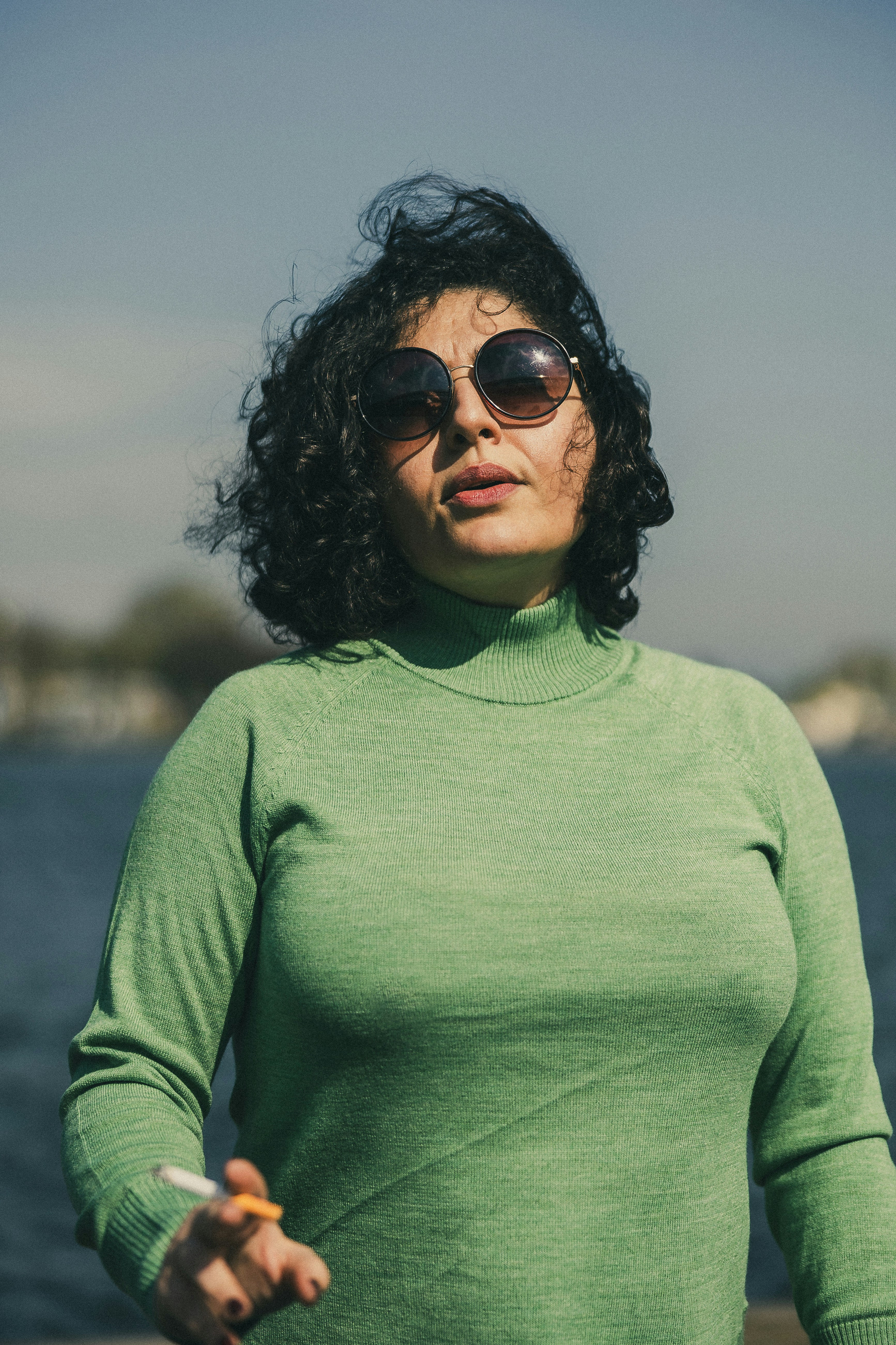 Emerald Turtleneck by the Water: A Wind-kissed Waterfront Portrait