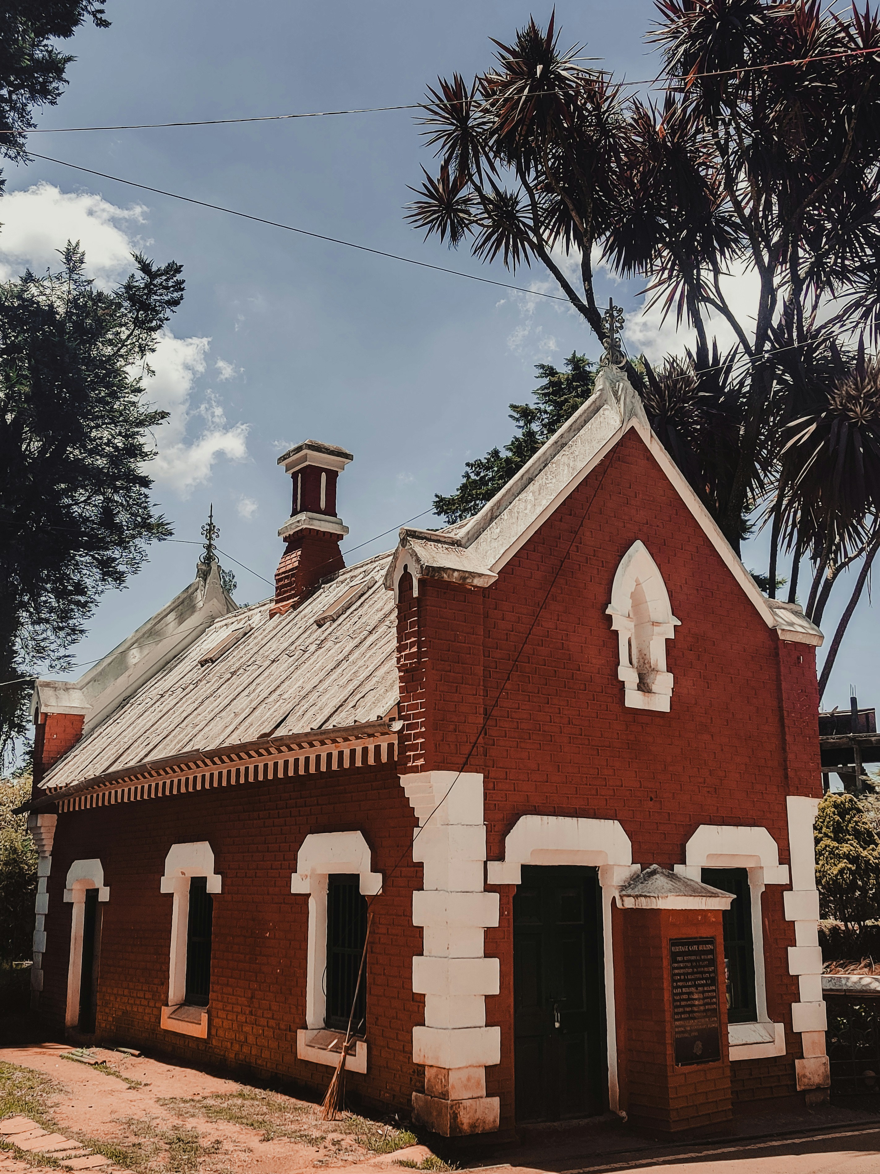 Red-brick chapel with white quoins under a cobalt sky, framed by dramatic palm silhouettes