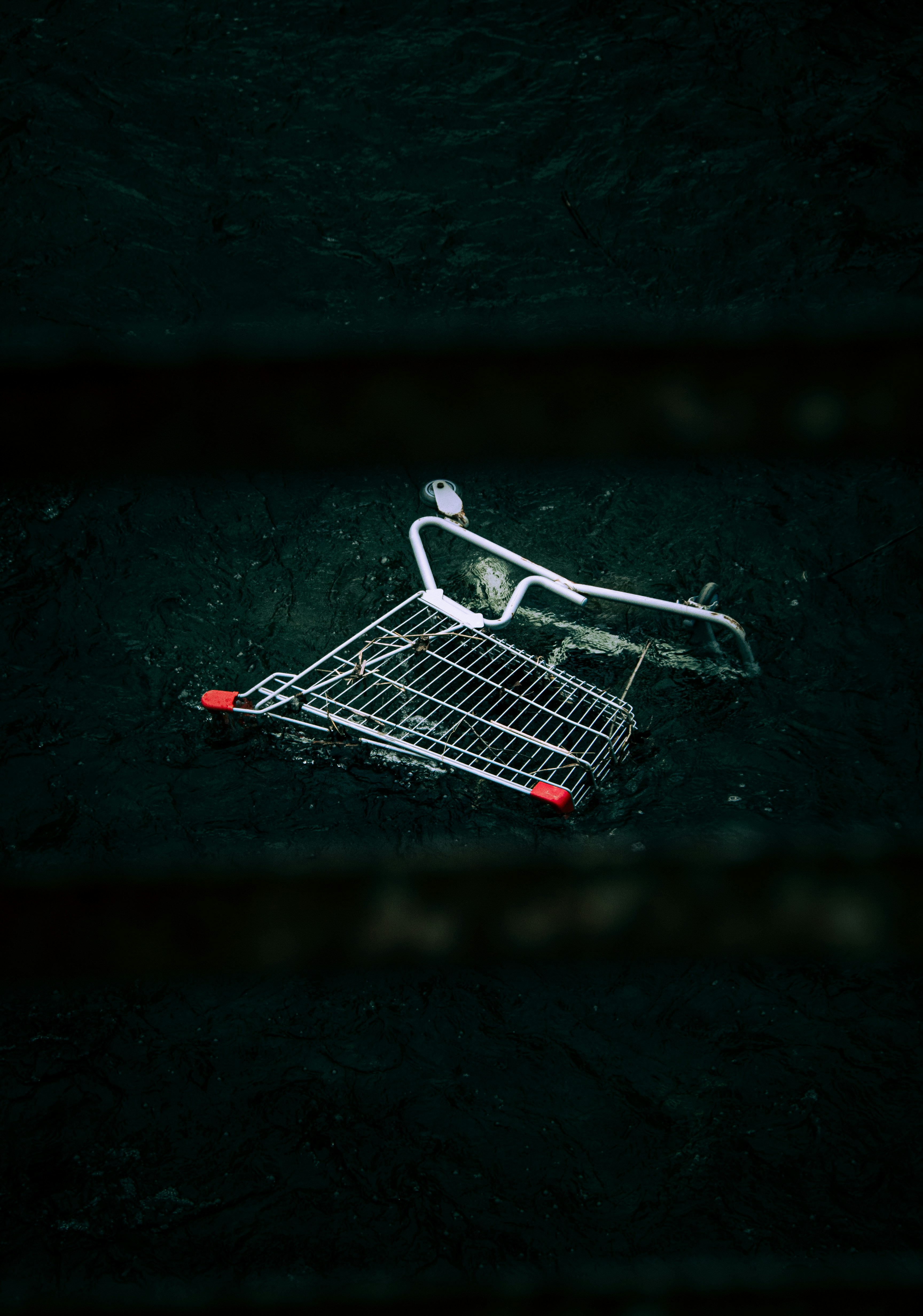 A shopping cart laying on its side in the water photo – Free Wallpaper ...
