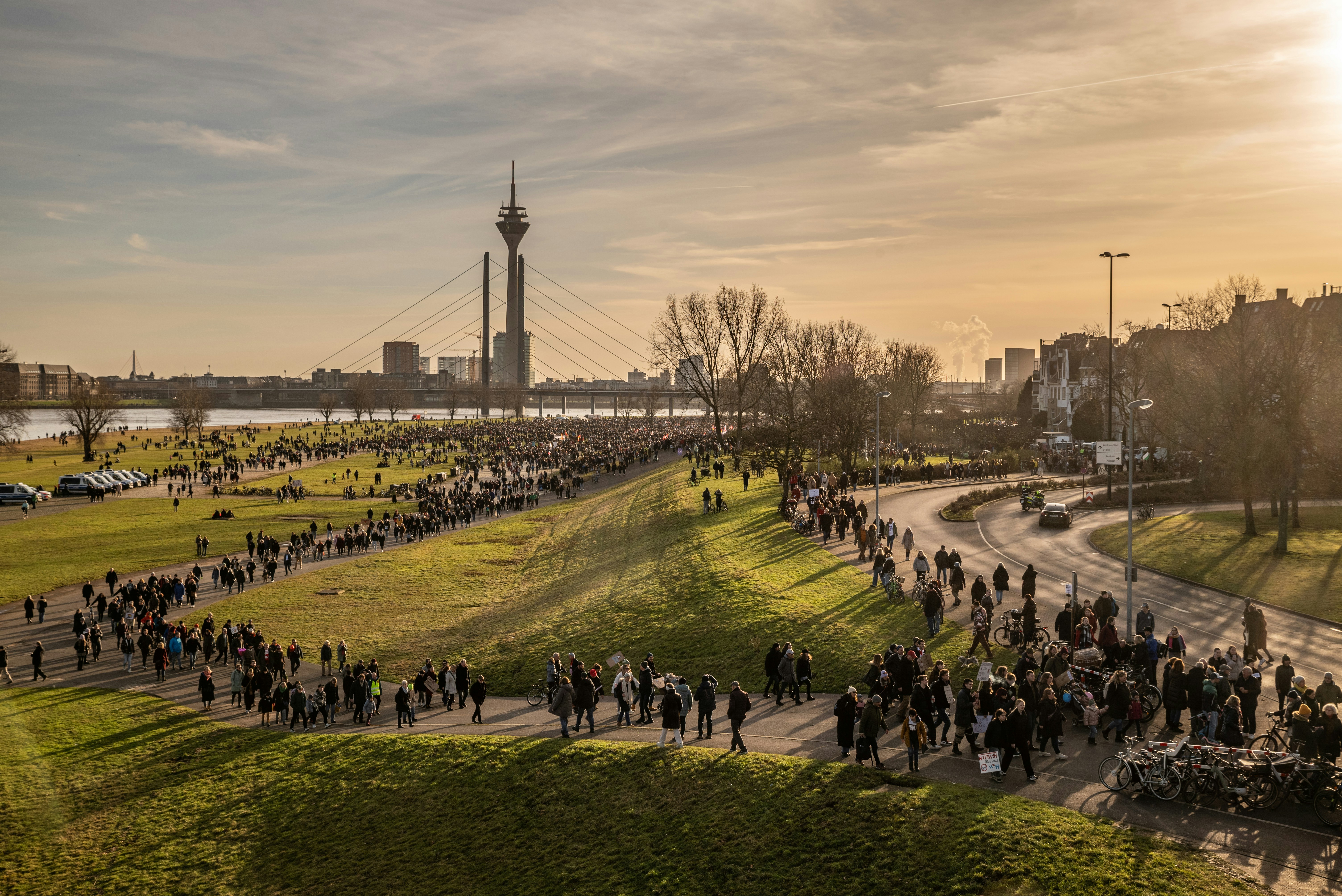 Sunlit Riverfront Marathon: A Sea of Pedestrians Winds Along the Park