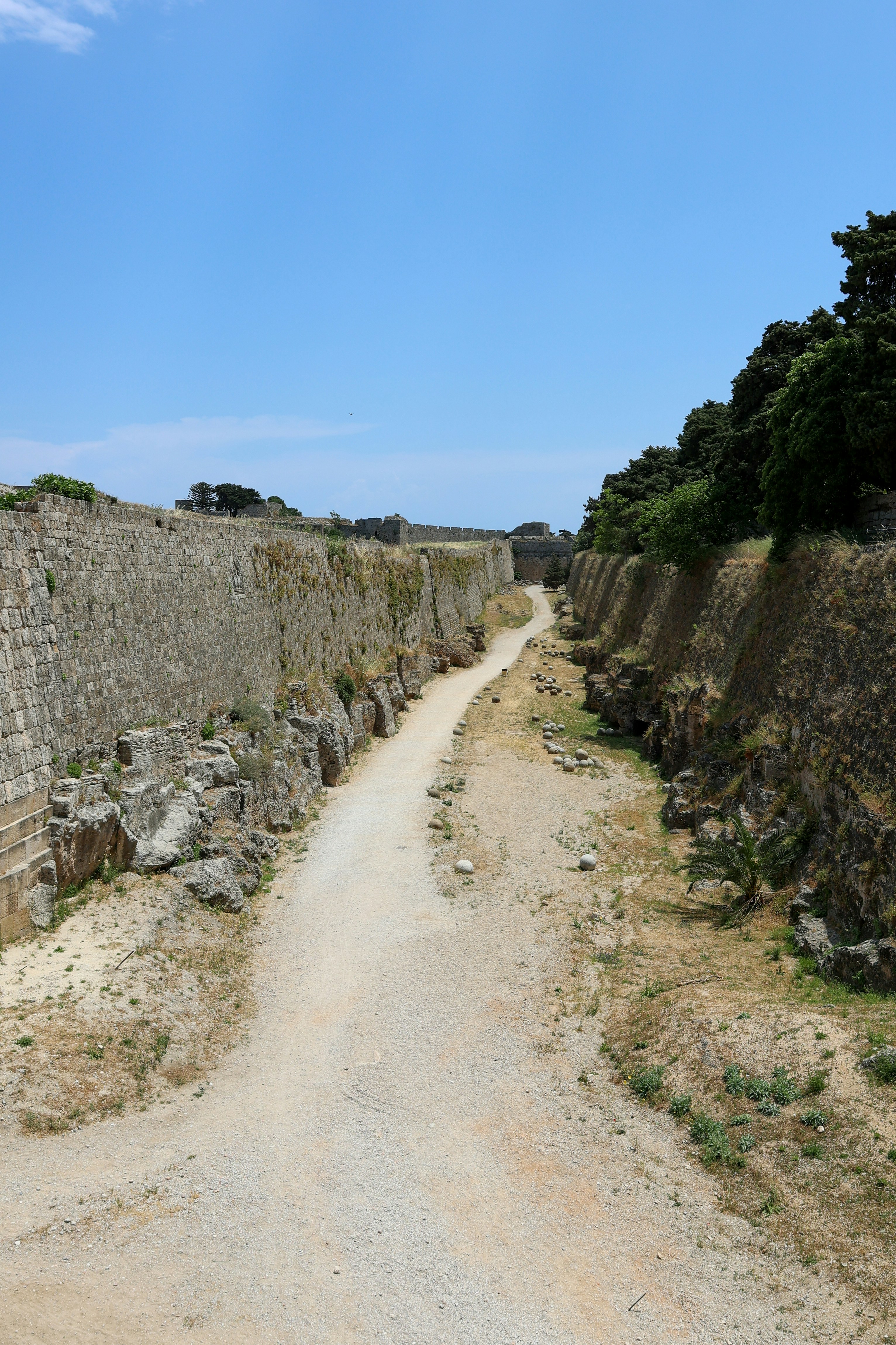 Sunlit Corridor Between Ancient Ramparts
