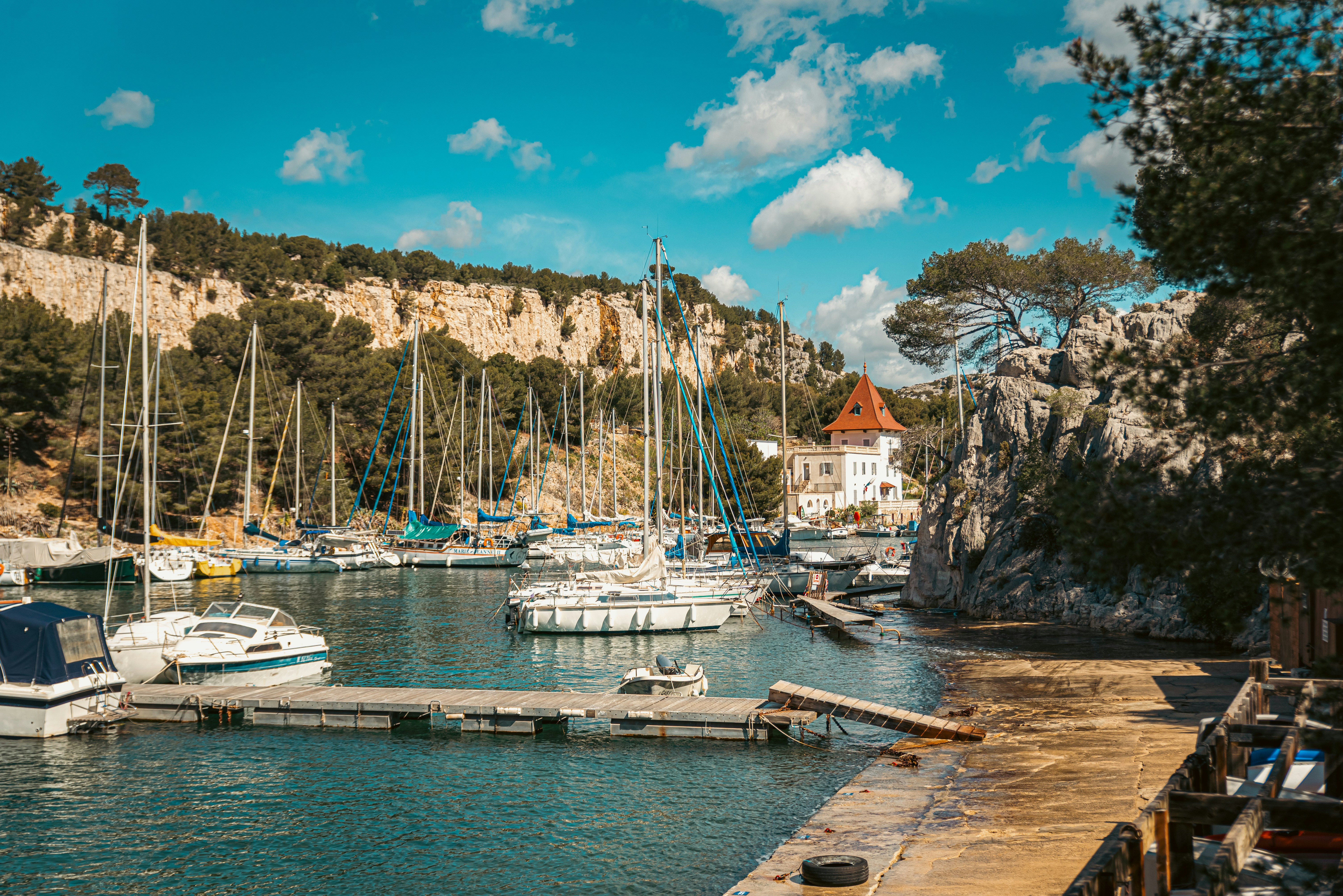 A harbor filled with lots of boats next to a cliff photo – Free Harbor ...