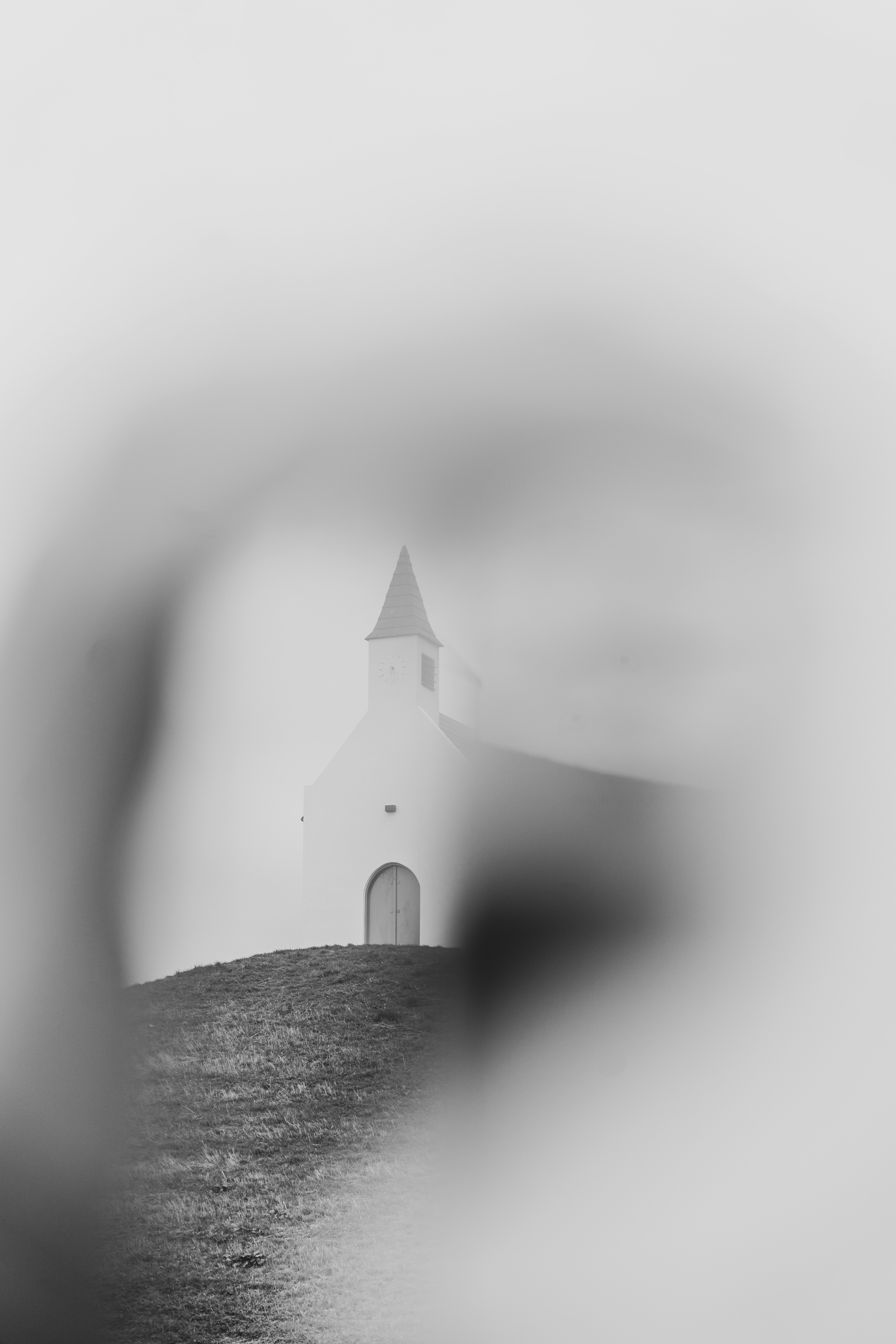 White Chapel on a Quiet Hill, Framed by a Soft Halo