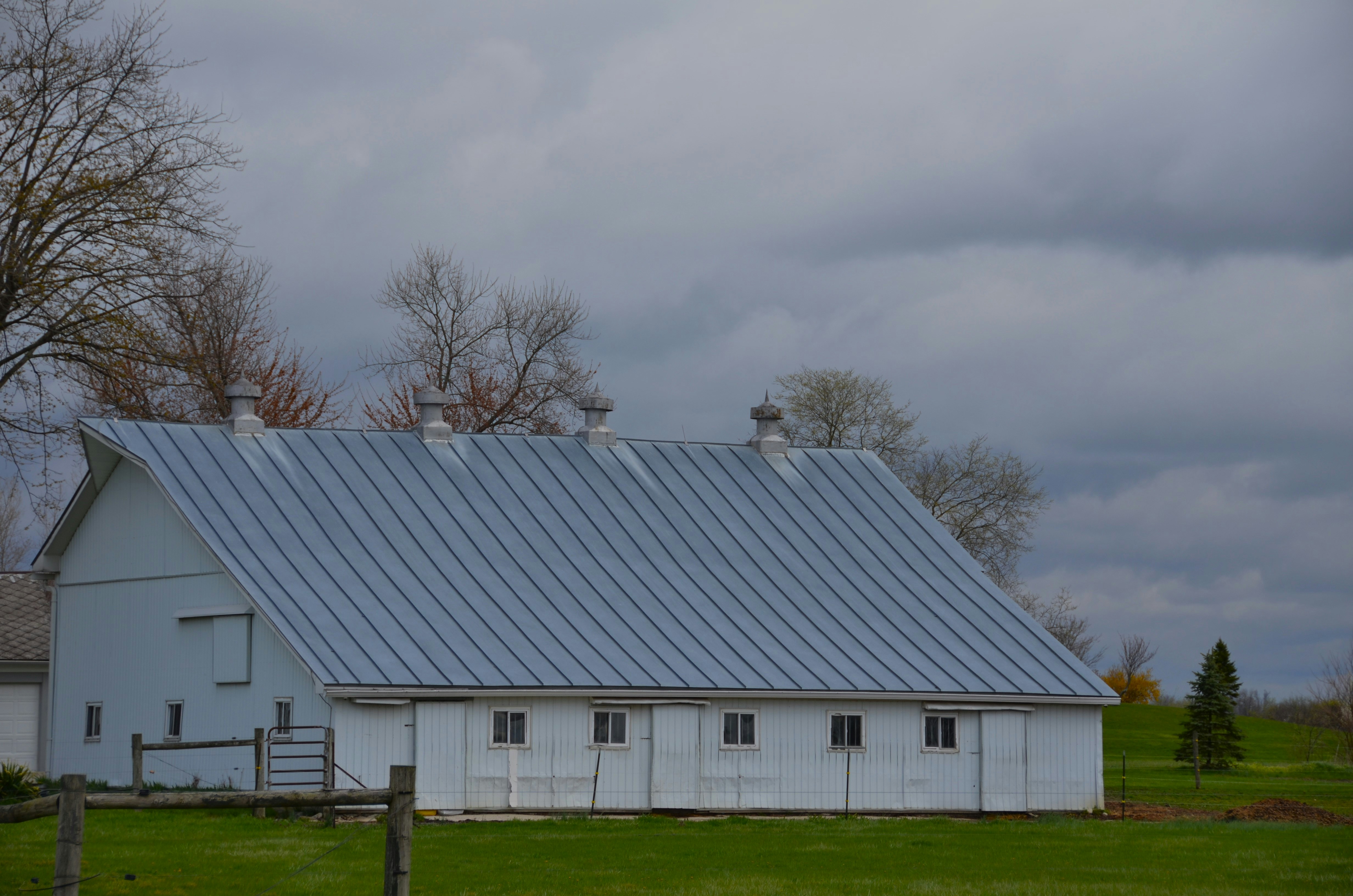 A white barn with a metal roof and a blue tin roof photo – Free ...