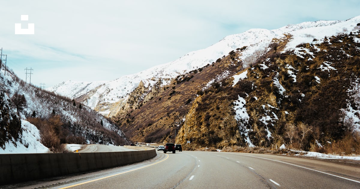 Foto Un coche que circula por una carretera junto a una montaña ... Foto Un coche que circula por una carretera junto a una montaña ...