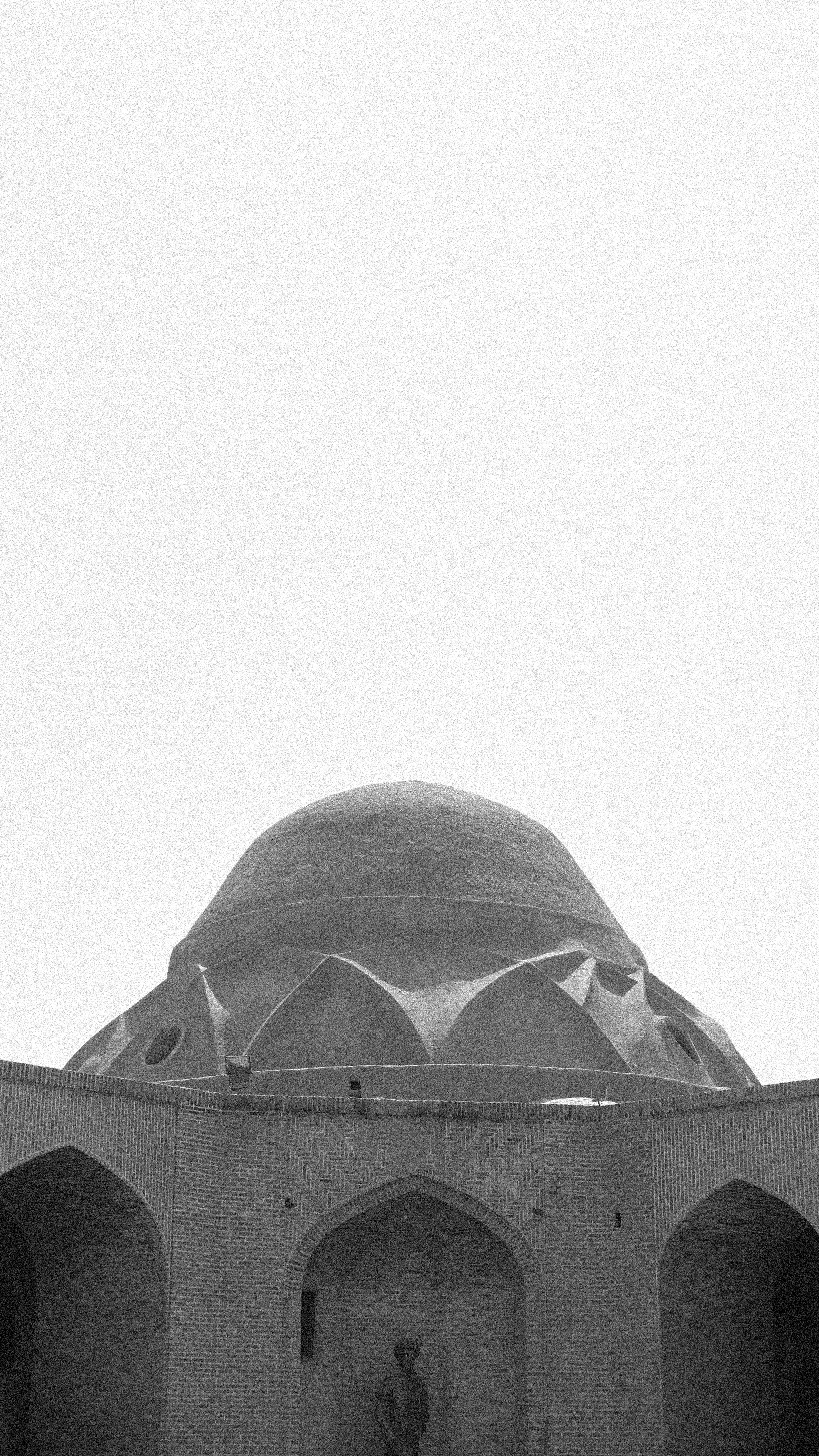 Dome Crest and Brick Arcades under a Pale Sky