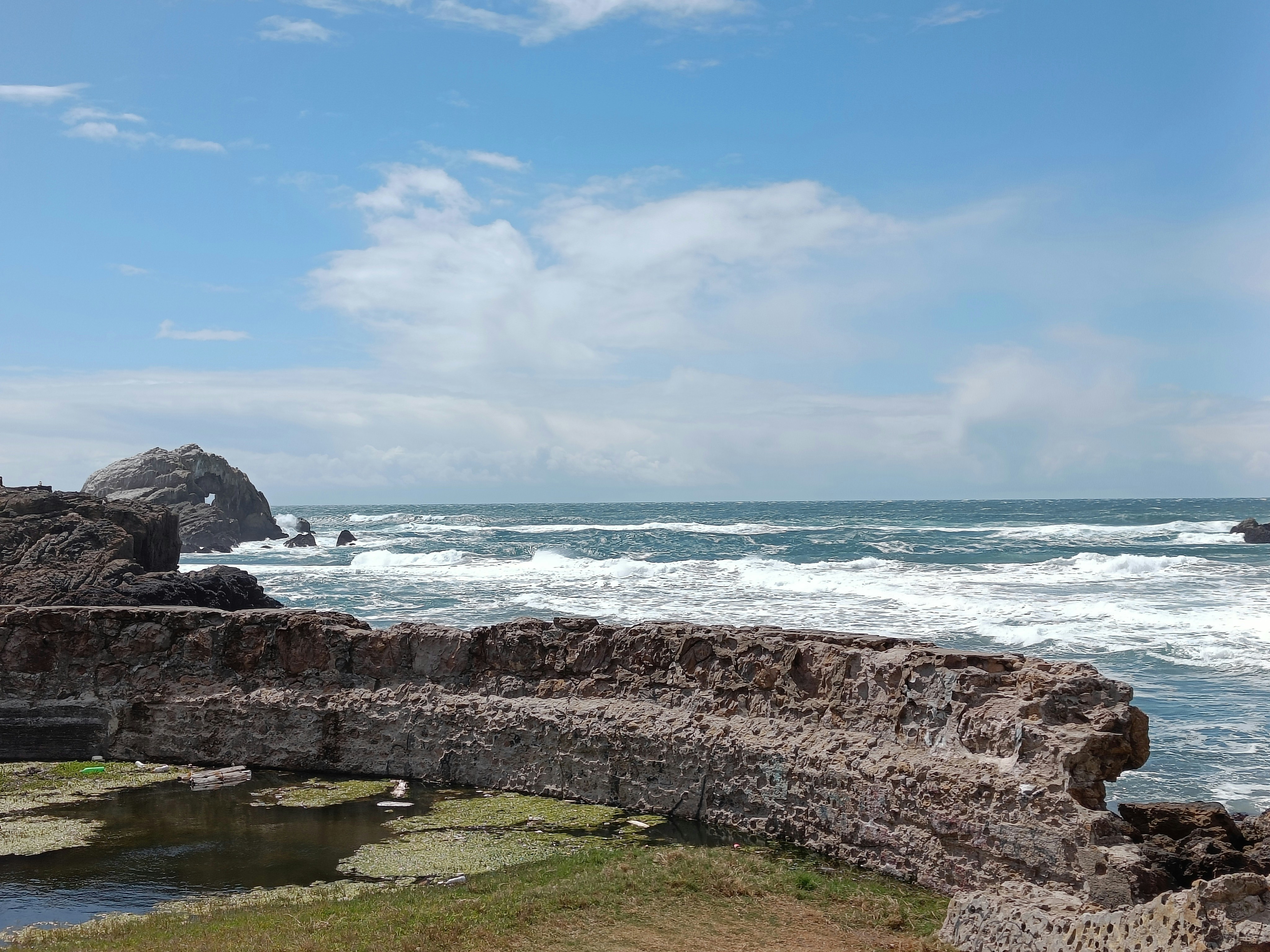 a person sitting on a rock near the ocean