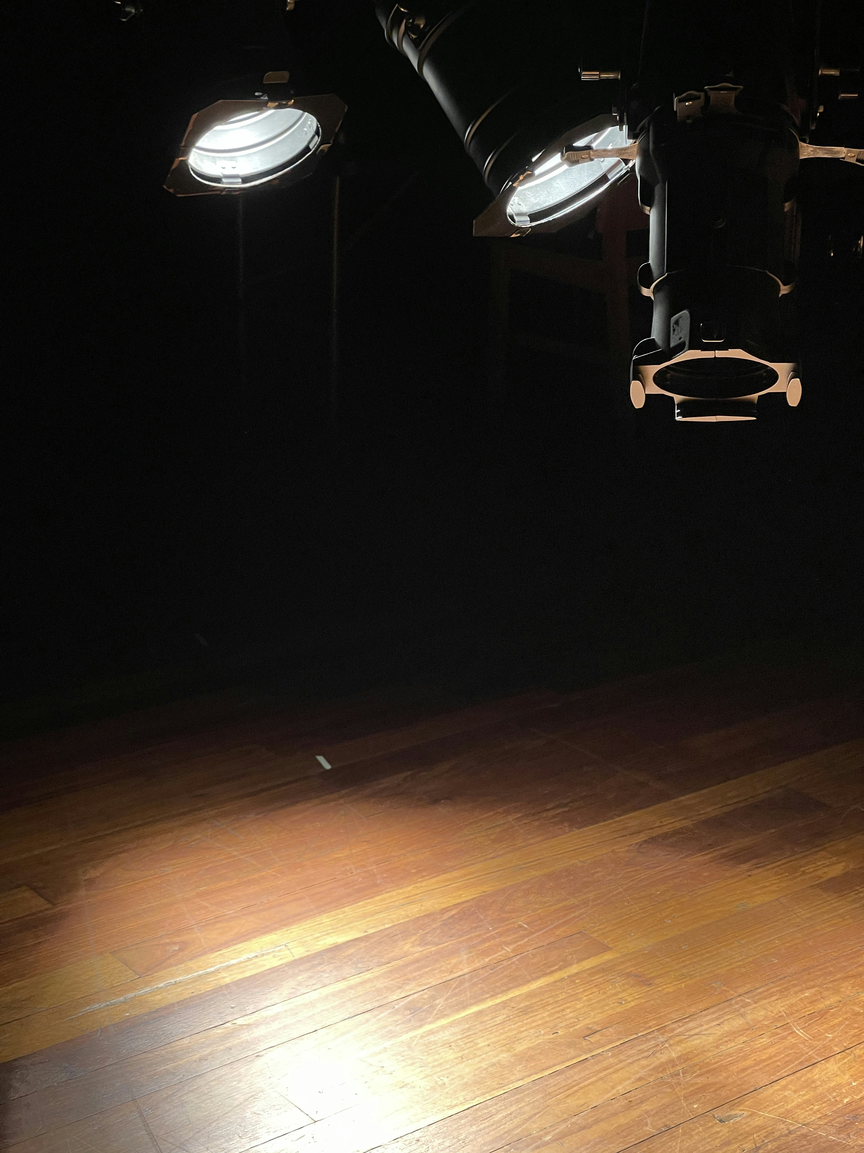 Warm Spotlight on a Silent Stage: Floodlights Meet Polished Wood