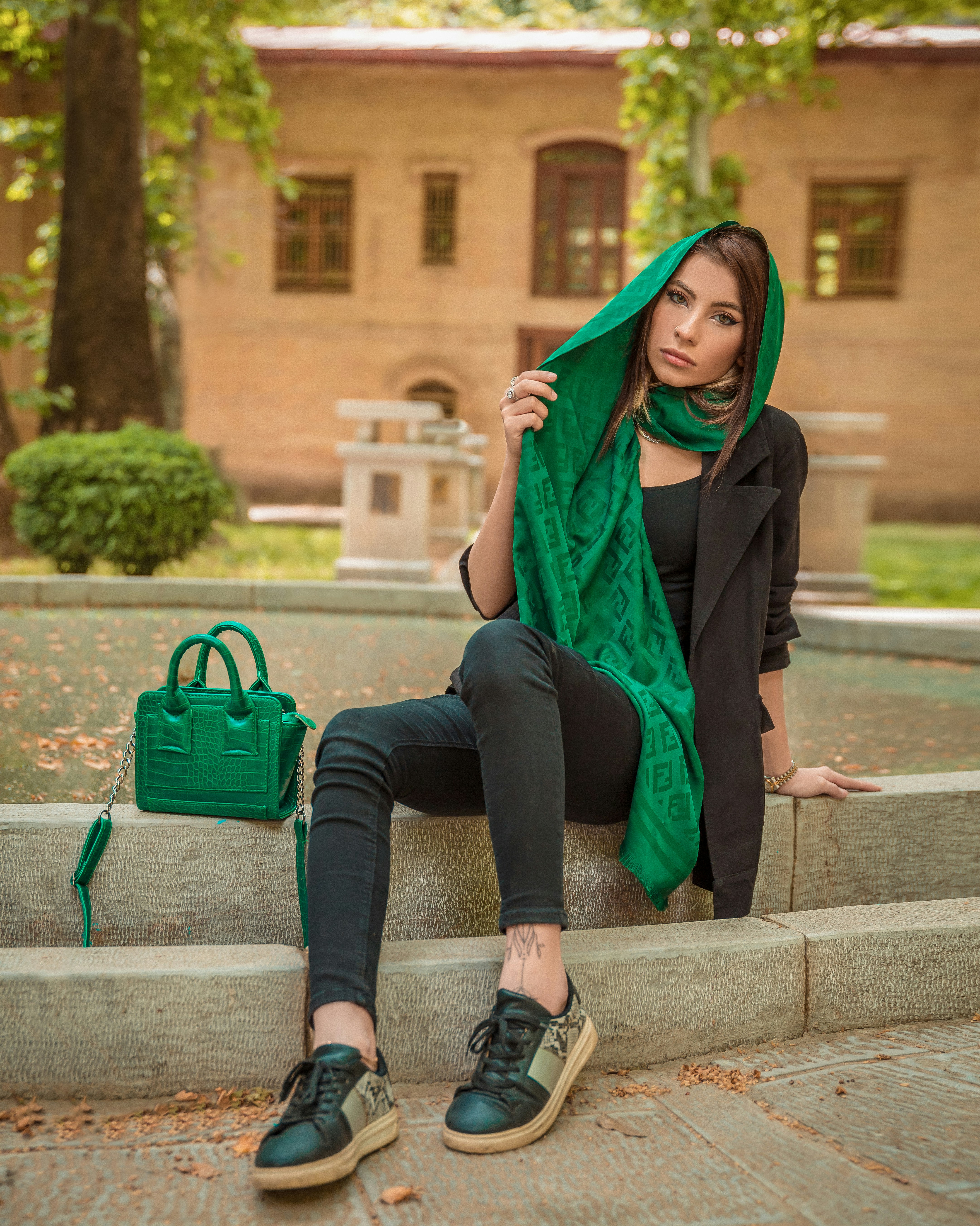 Emerald scarf and city calm: a portrait in green on stone steps