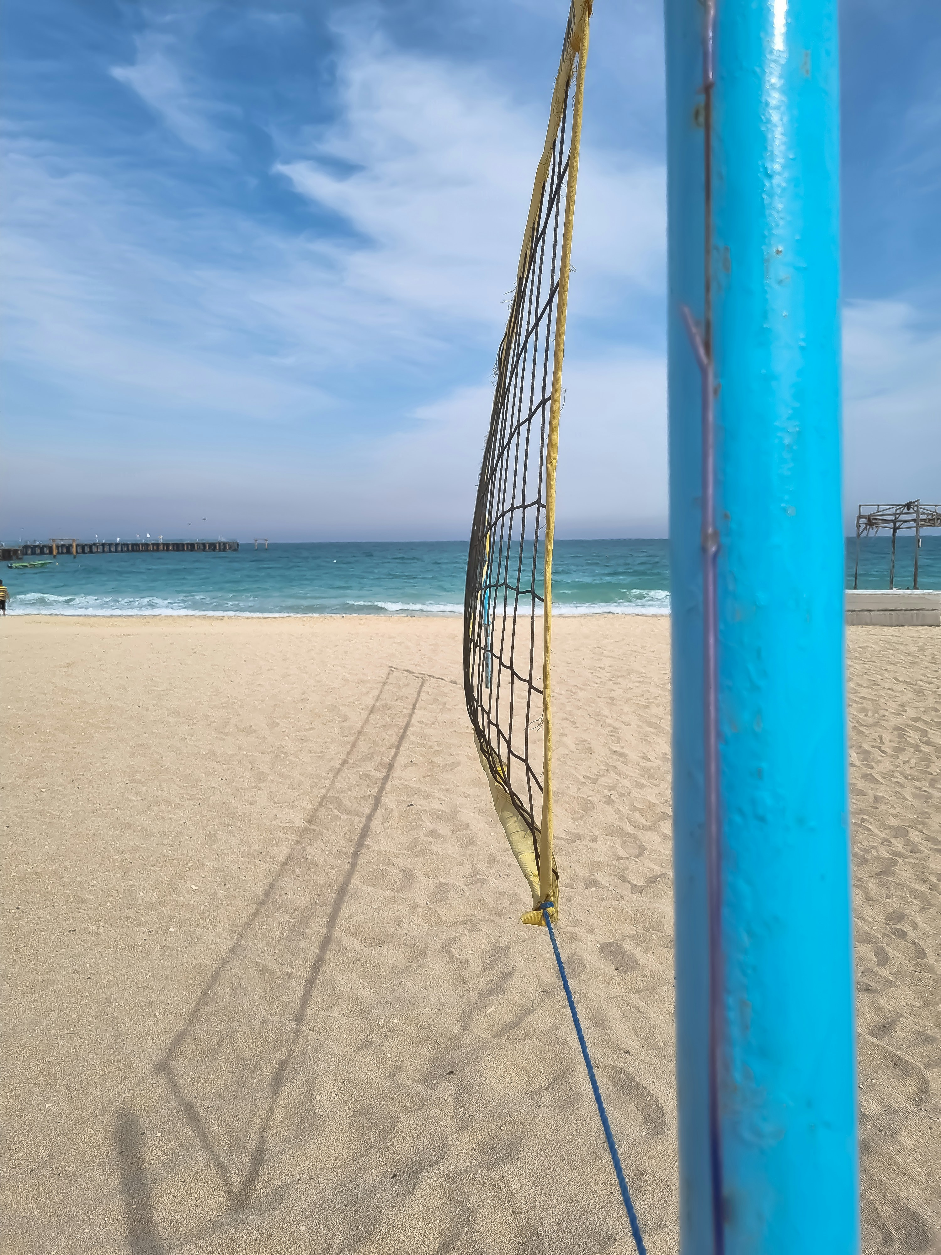 A blue pole on a beach with a volleyball net photo – Free Beach ...