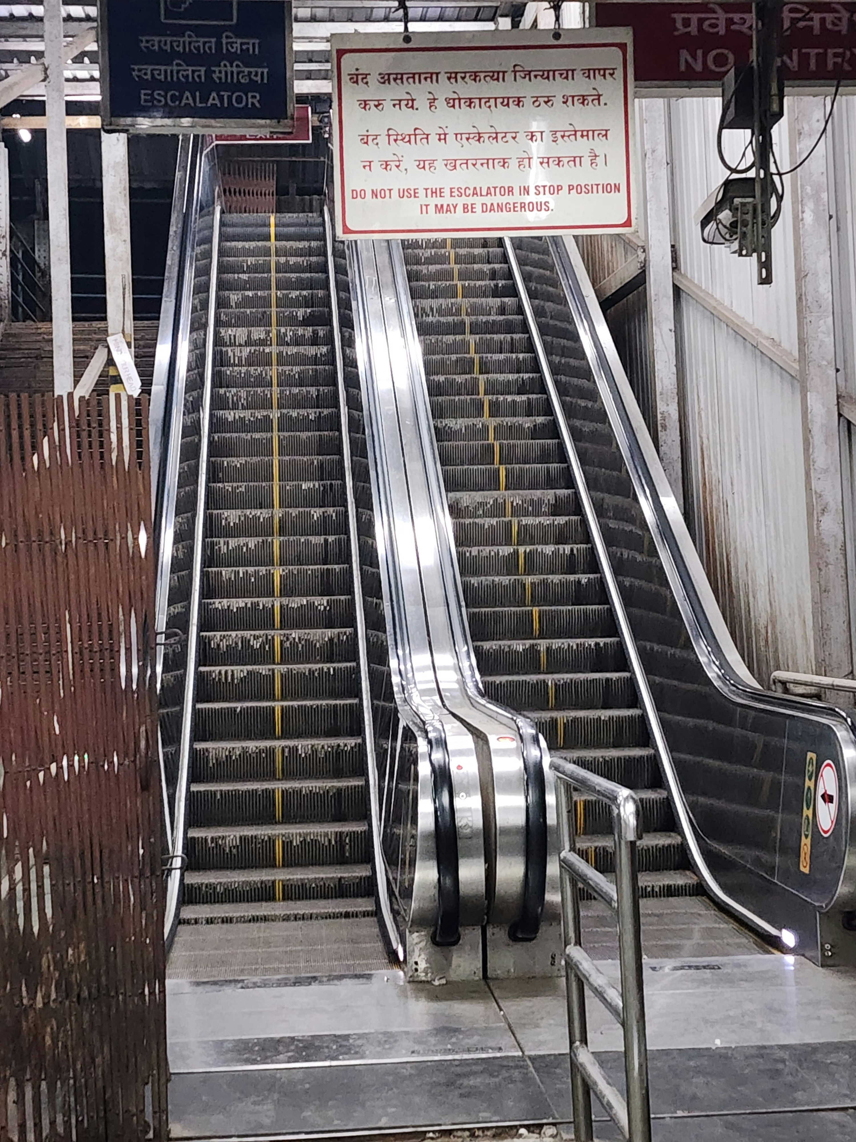 Una escalera mecánica en una estación de metro con un letrero encima ...