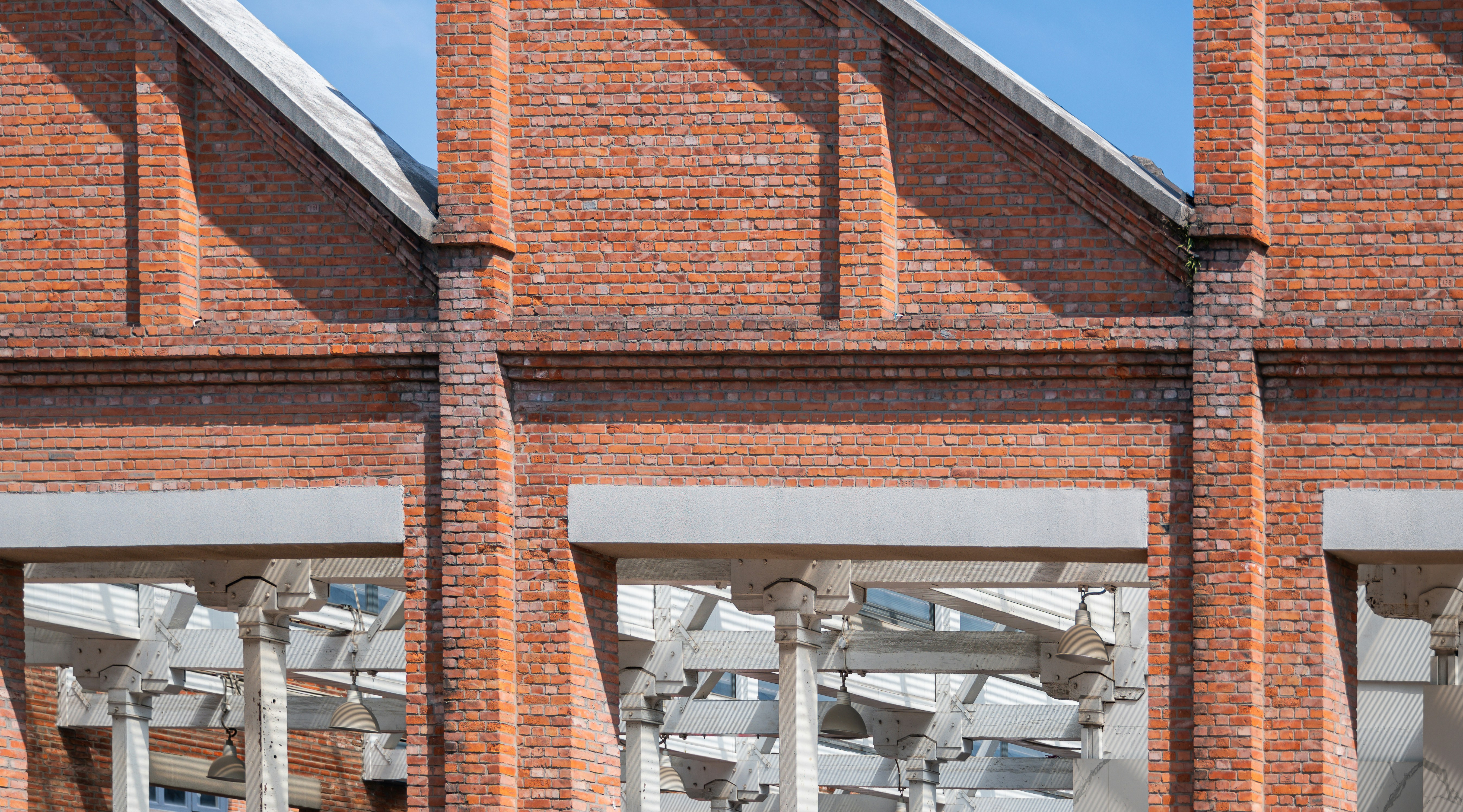 Sunlit Brickwork Framed by Glass-and-Steel Arches