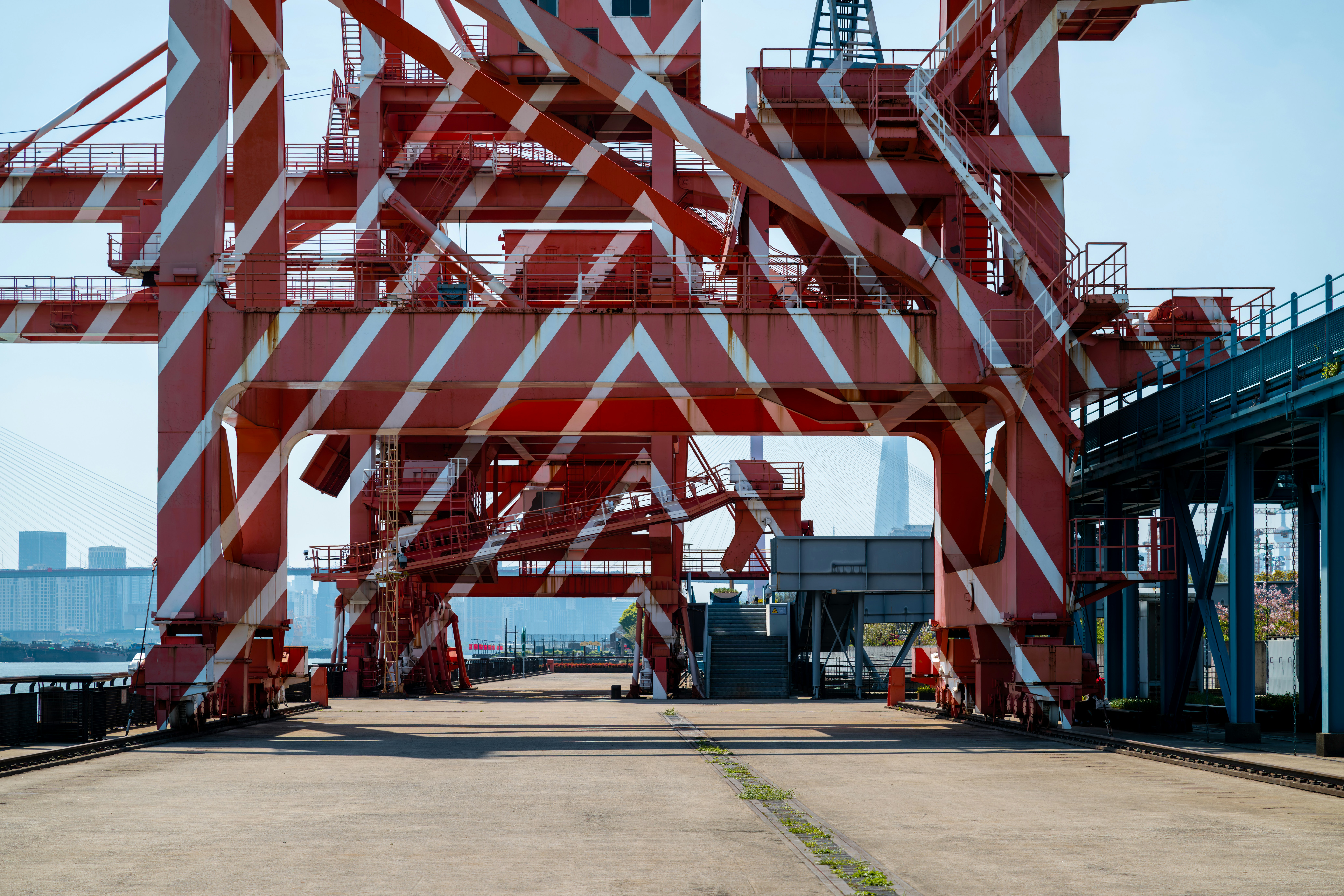 Crane Cathedral: Red Steel Arches Framing a Vanishing Dock